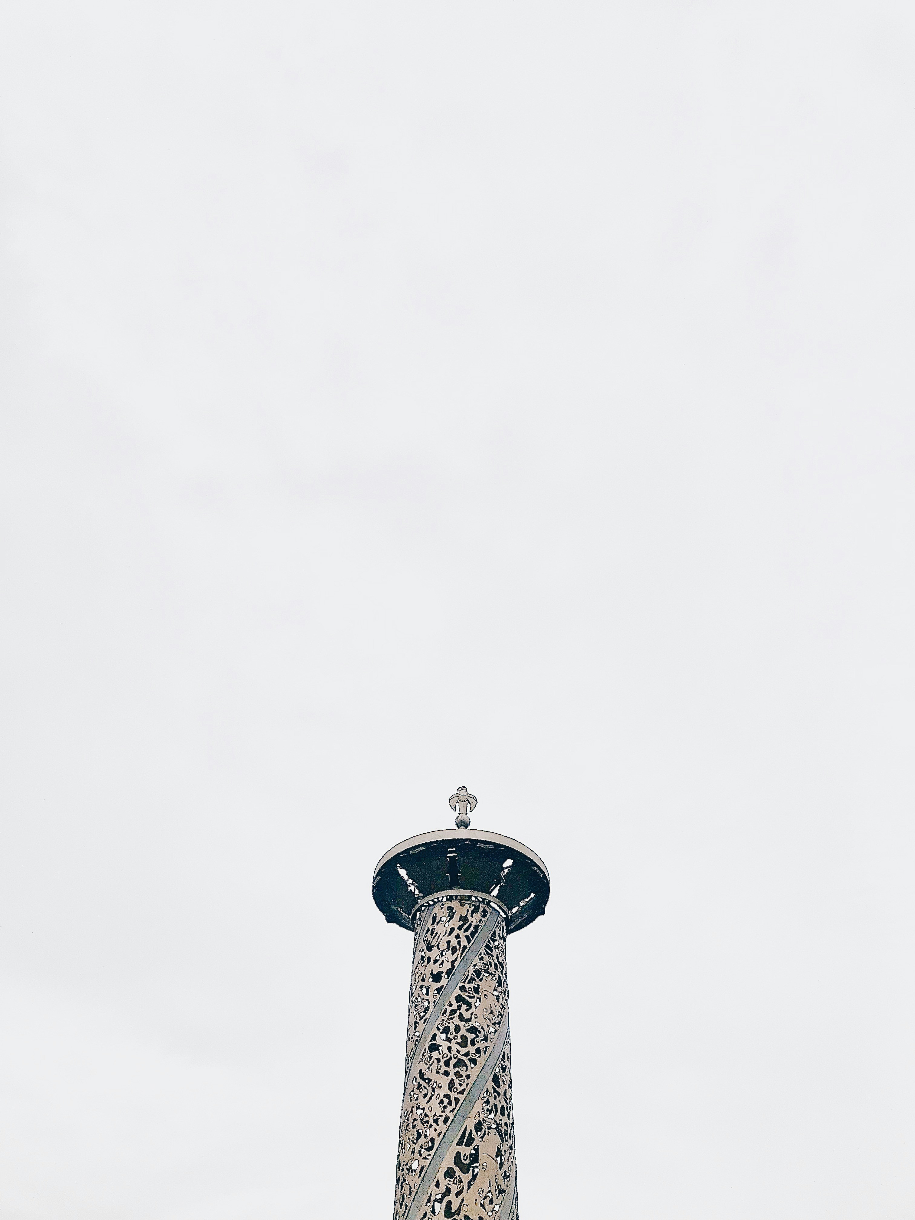 The Spiral Lattice Tower Reaching Into a Pale Overcast