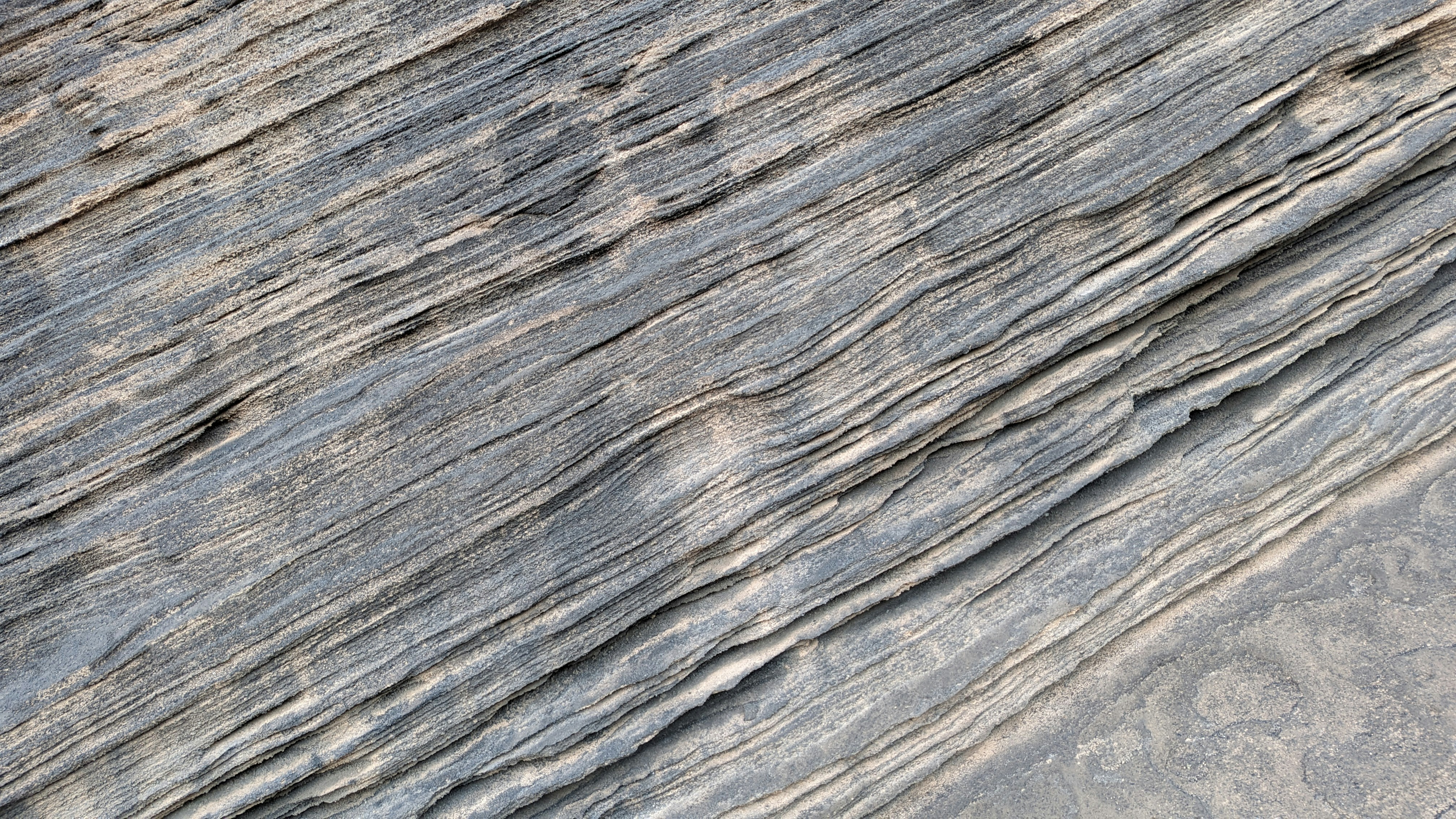 Abstract pattern of weathered rock layers with subtle color variations.