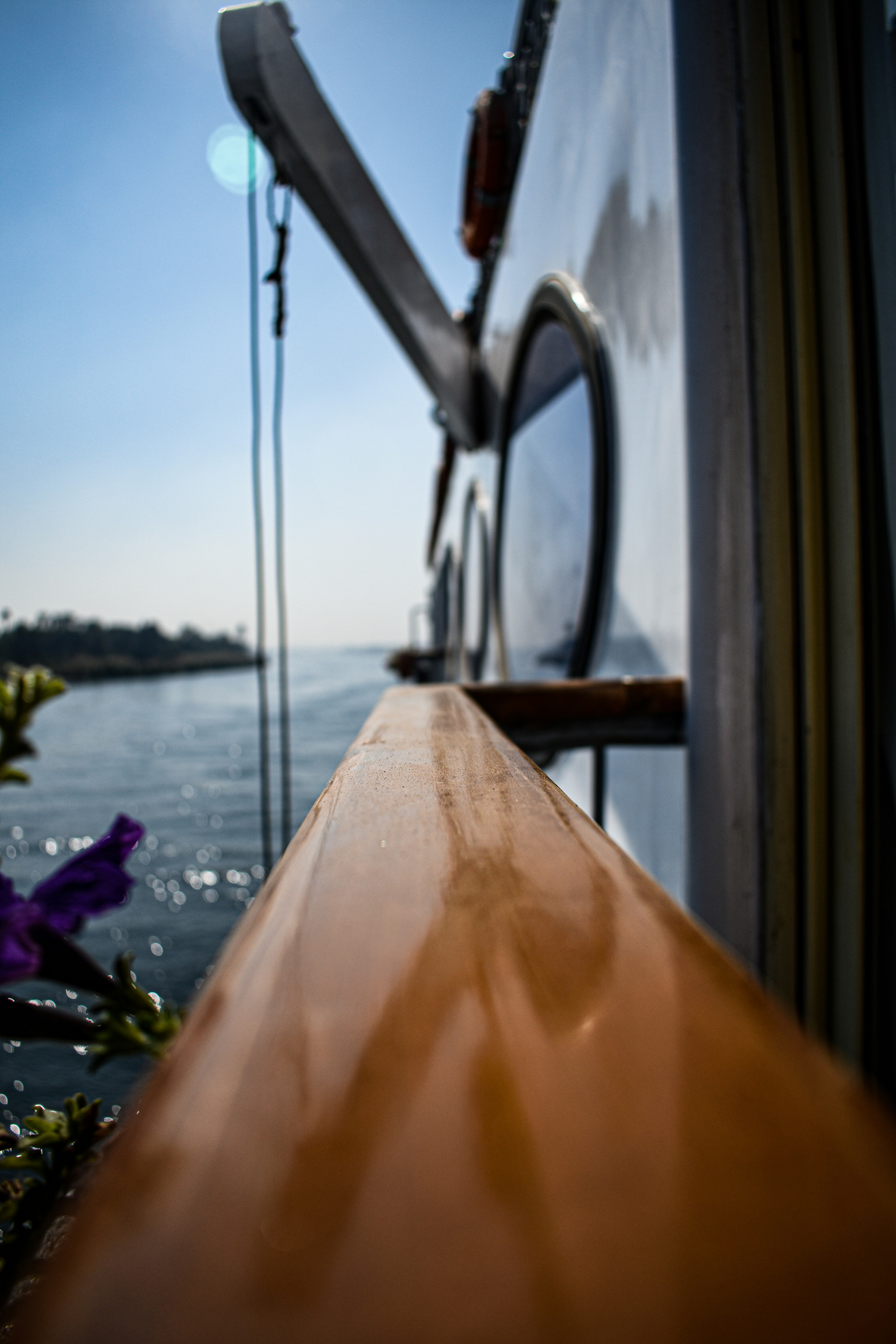 Sunlit Cedar Rail: A Vessel's Close-Range Journey Along the Hull