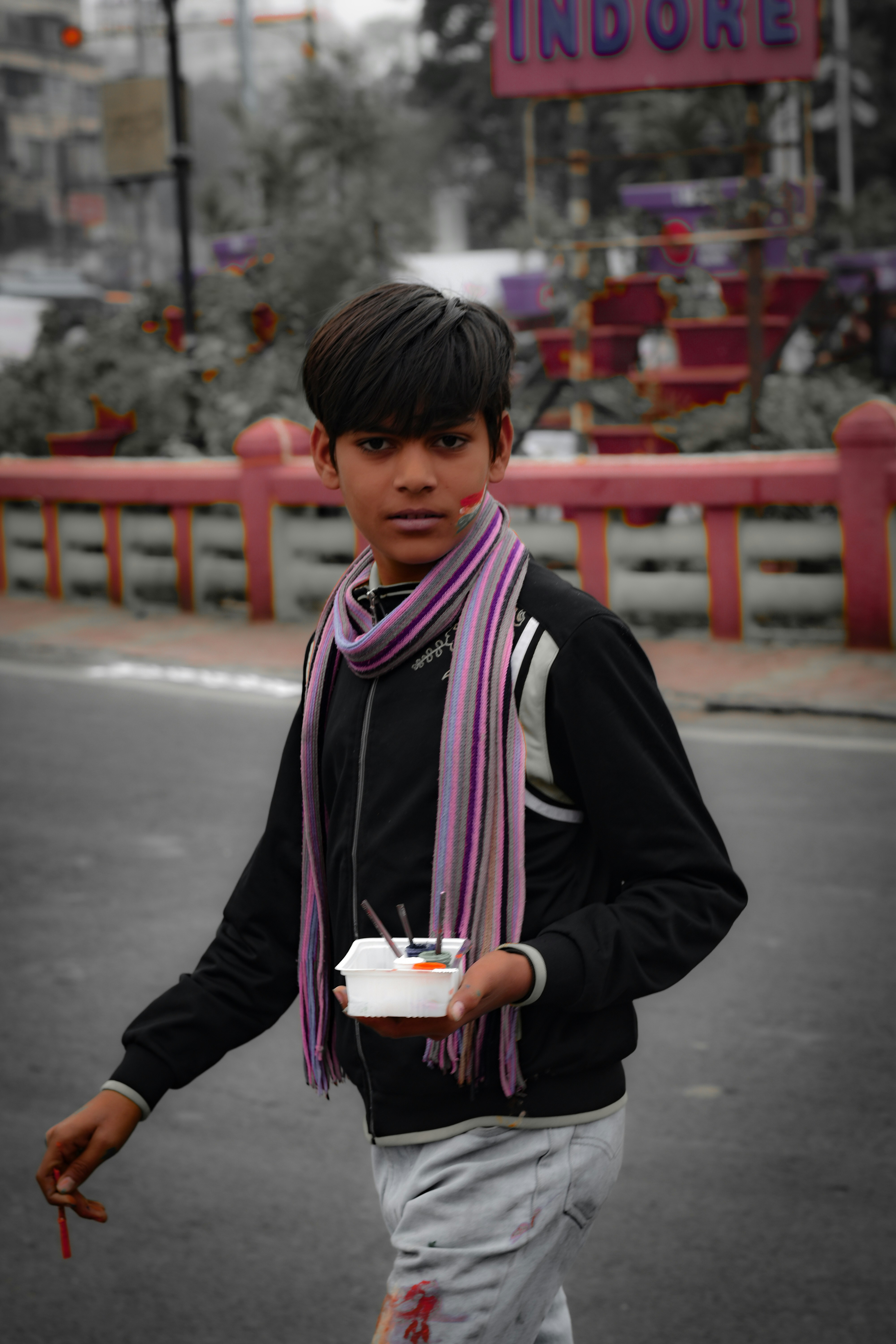 Un jeune garçon marchant dans une rue tenant une tasse de café photo ...