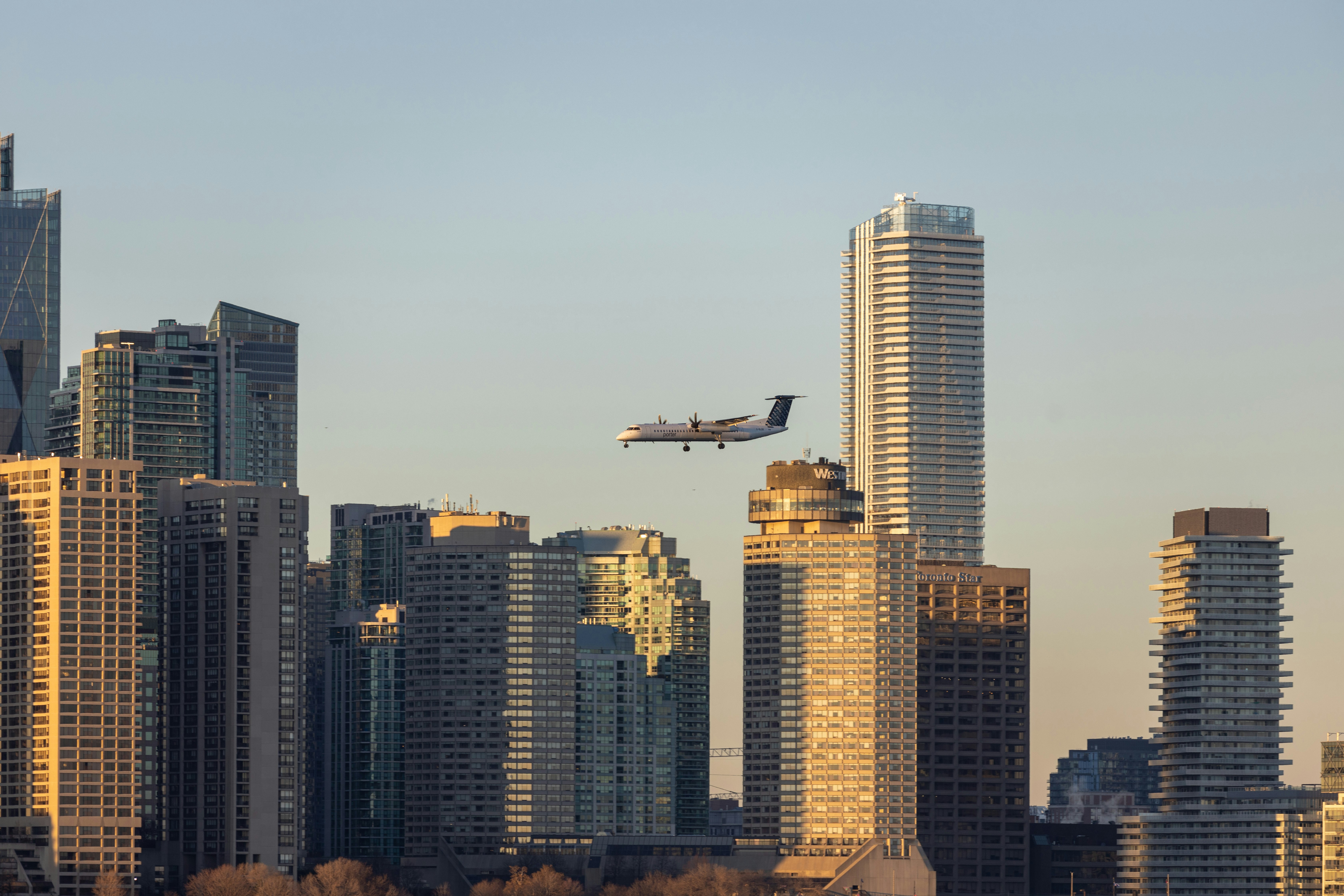 Un avion survolant une ville avec de grands immeubles photo – Photo ...