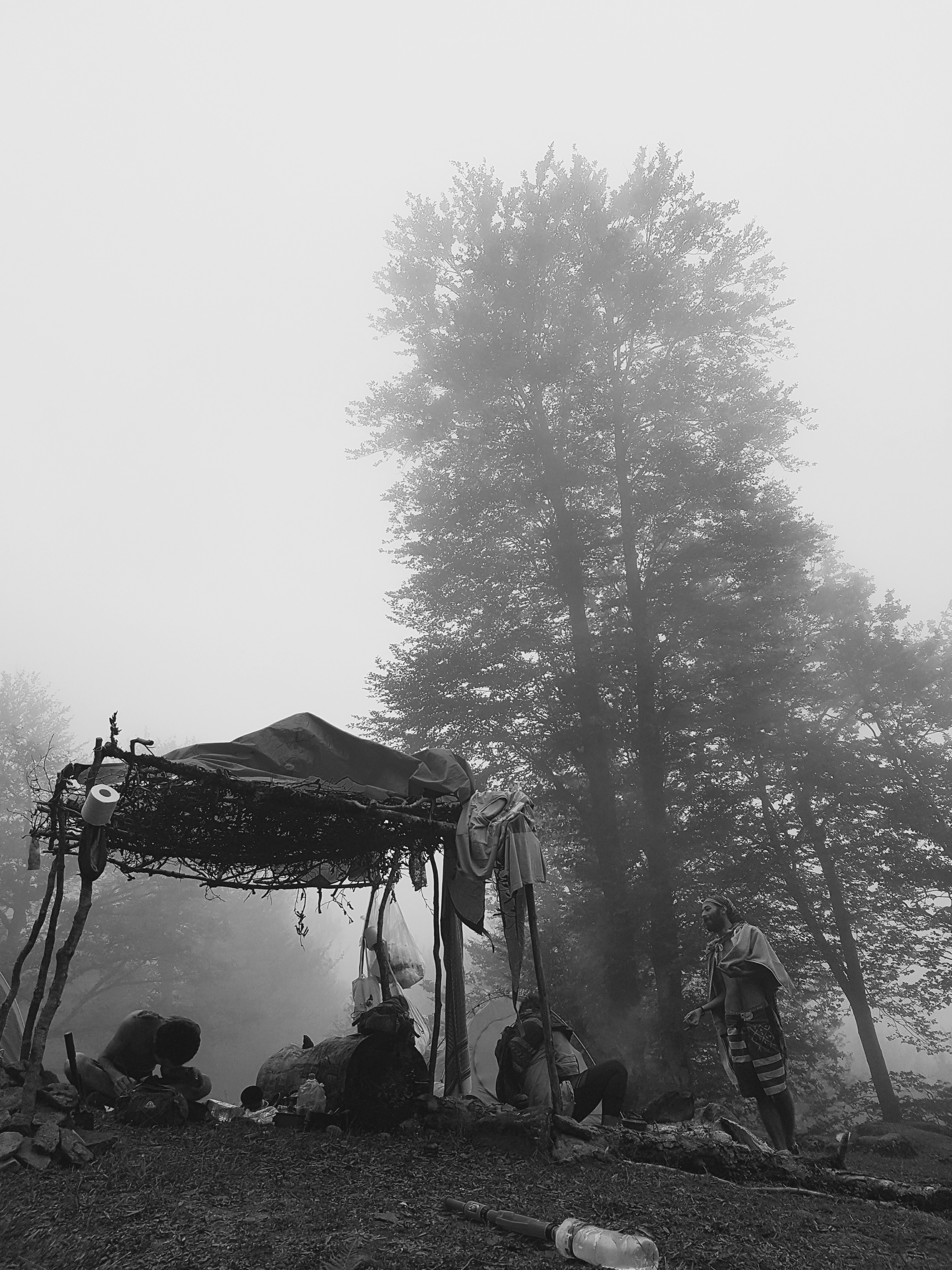 a black and white photo of a tent in the woods