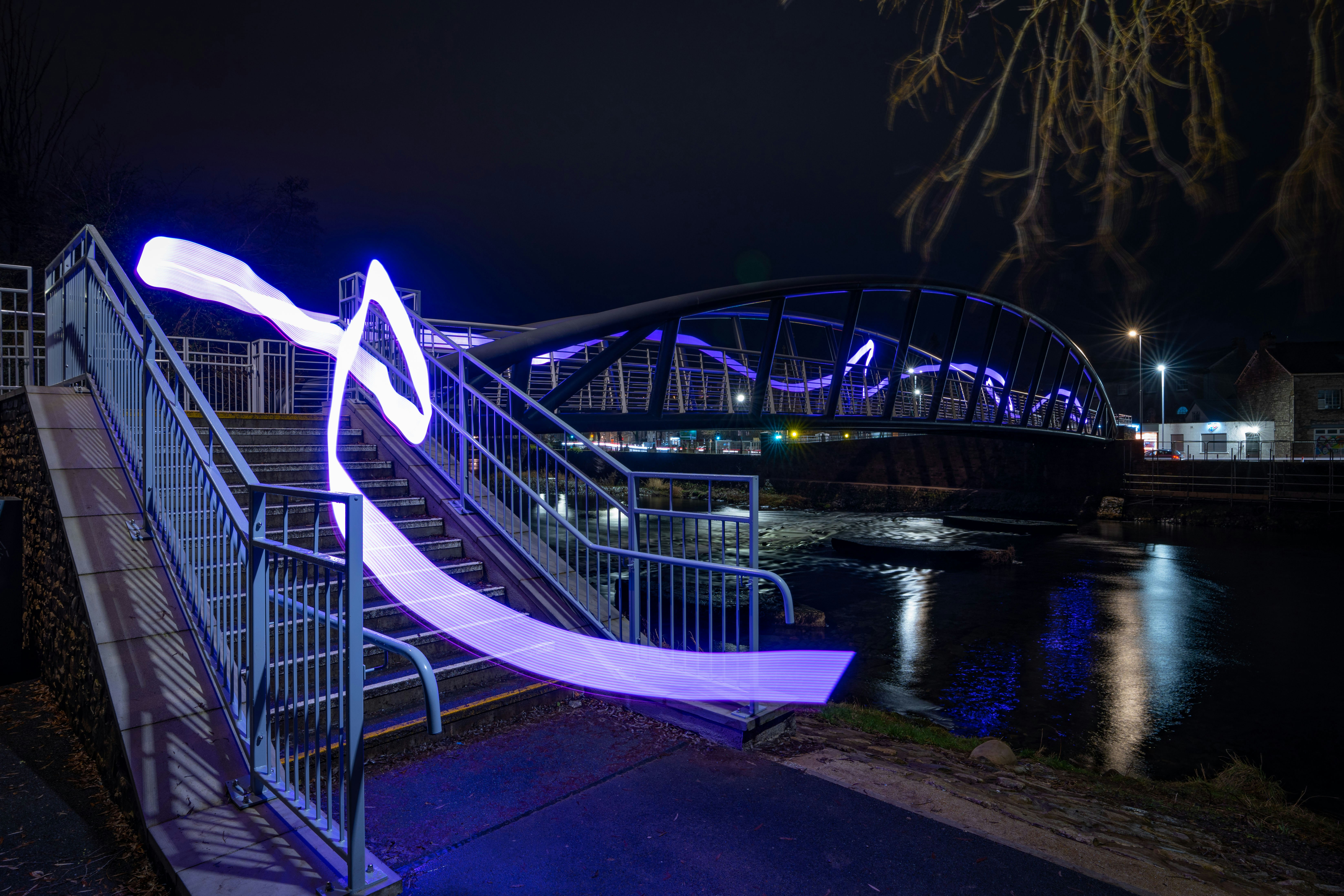 Glowing Ribbon Over River: Nightscape of a Modern Footbridge
