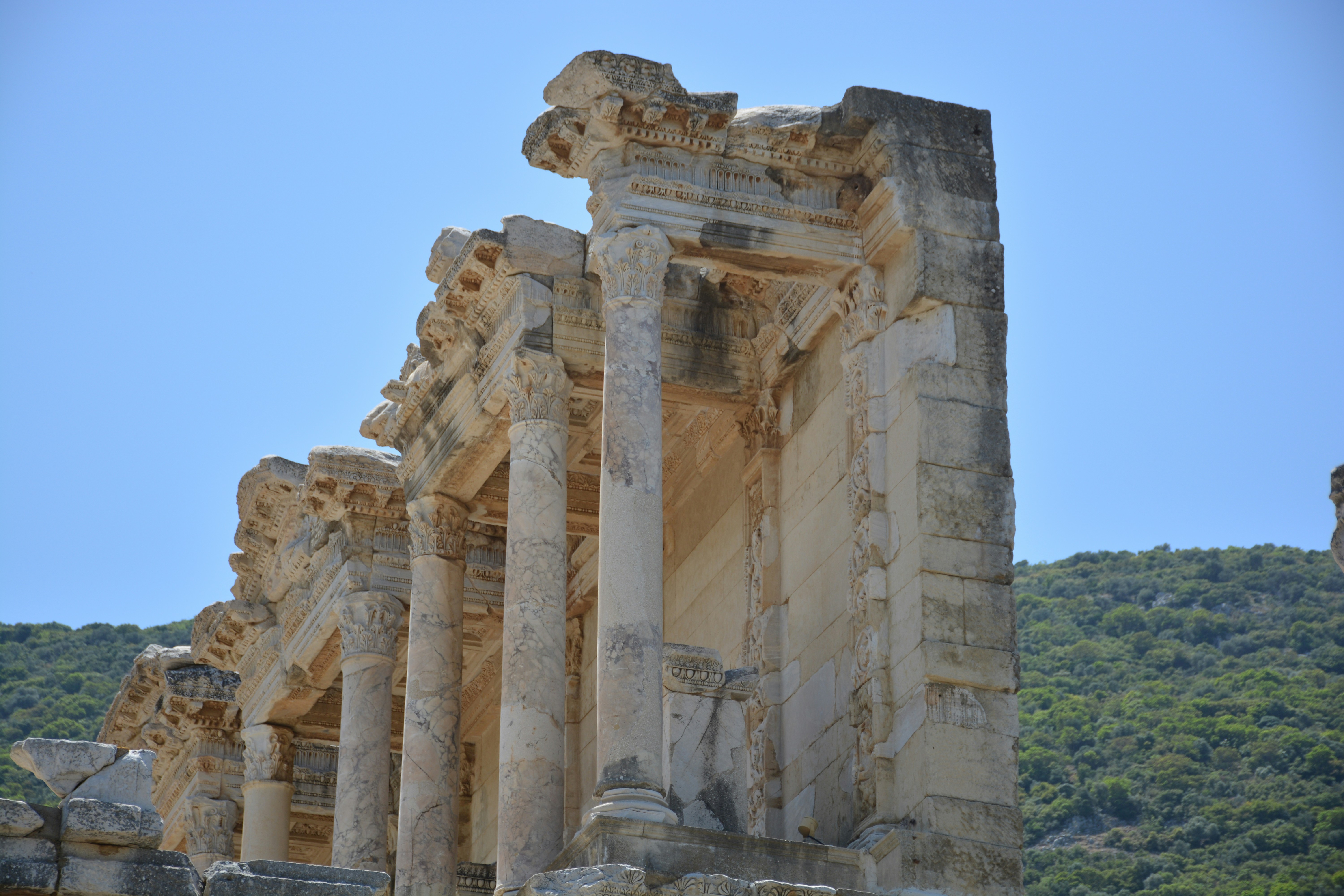 Ruins of ancient stone columns standing tall beneath a bright blue sky.