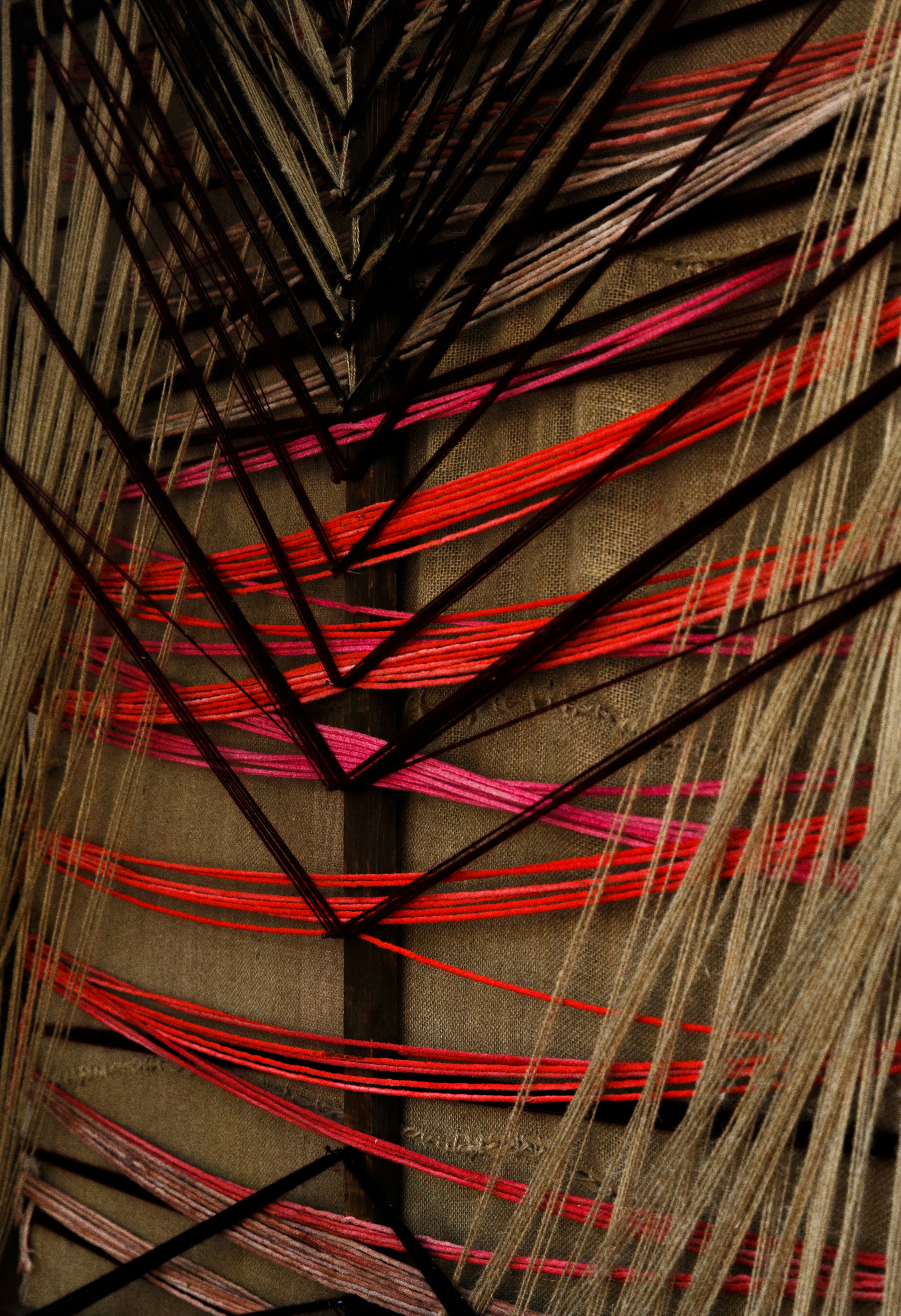 A close up of a weaving machine with red and pink threads photo – Free ...