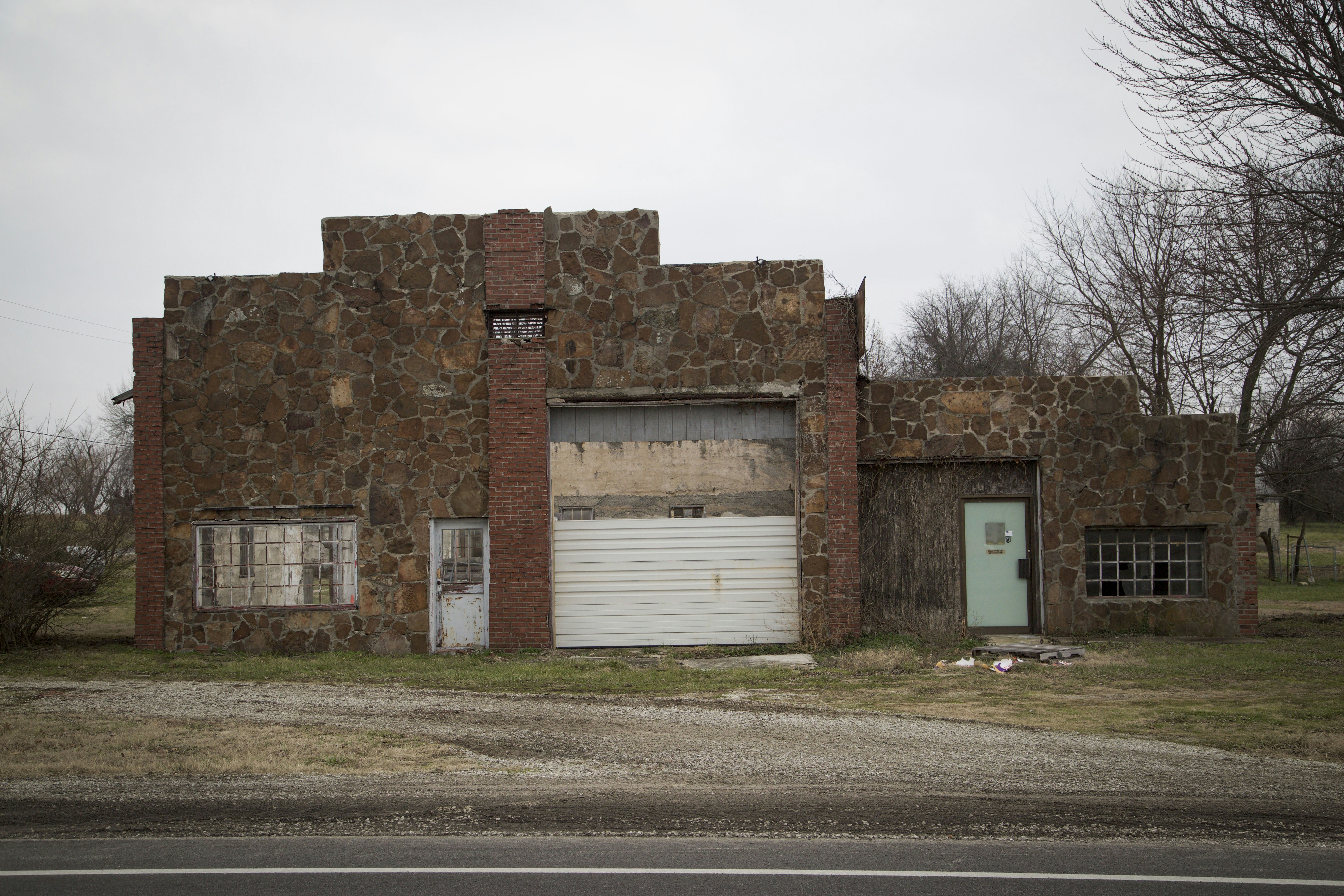 An old run down building with a garage photo – Free Abondoned Image on ...