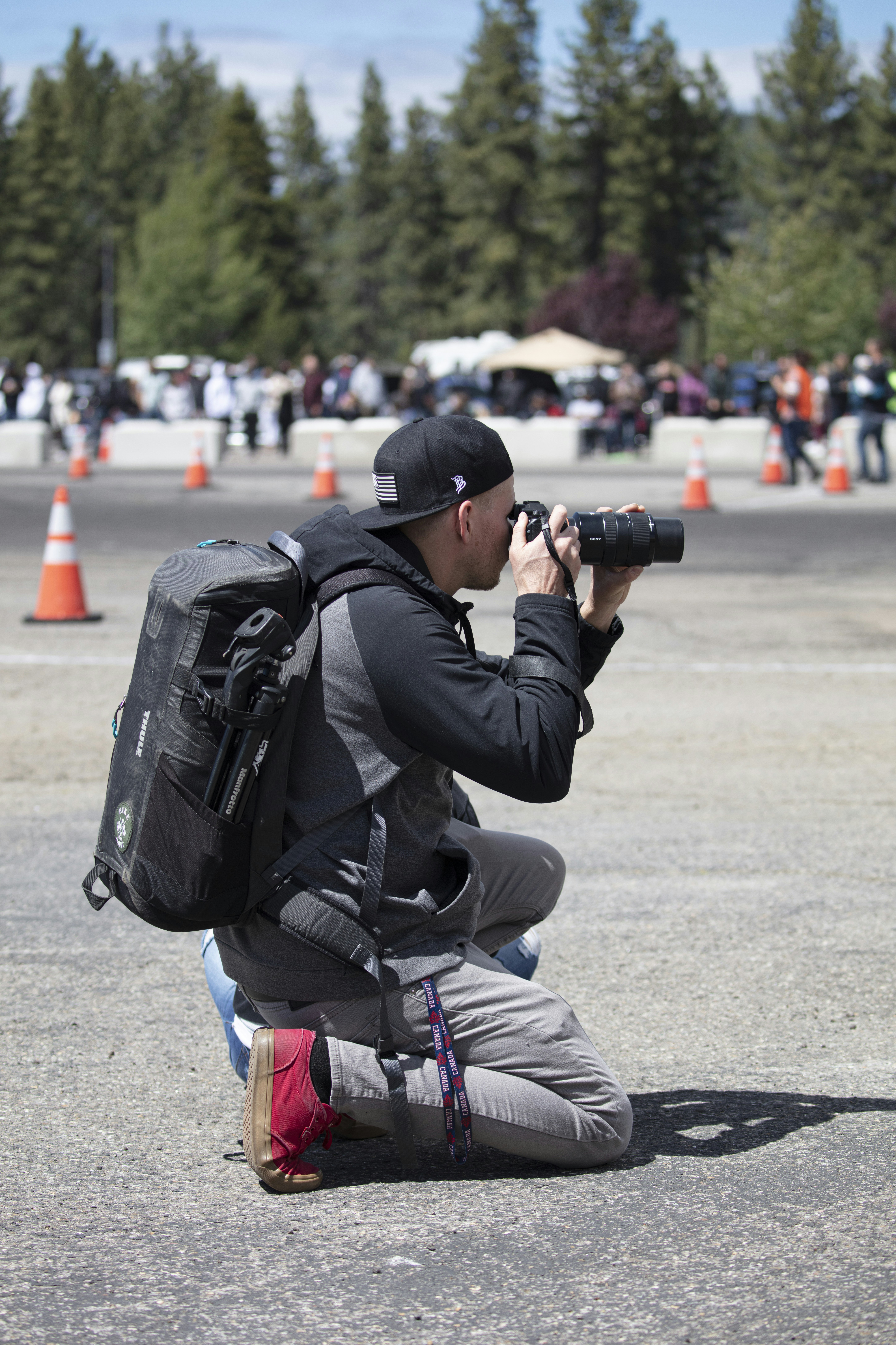 A man kneeling down with a camera in his hand photo – Free Photography ...