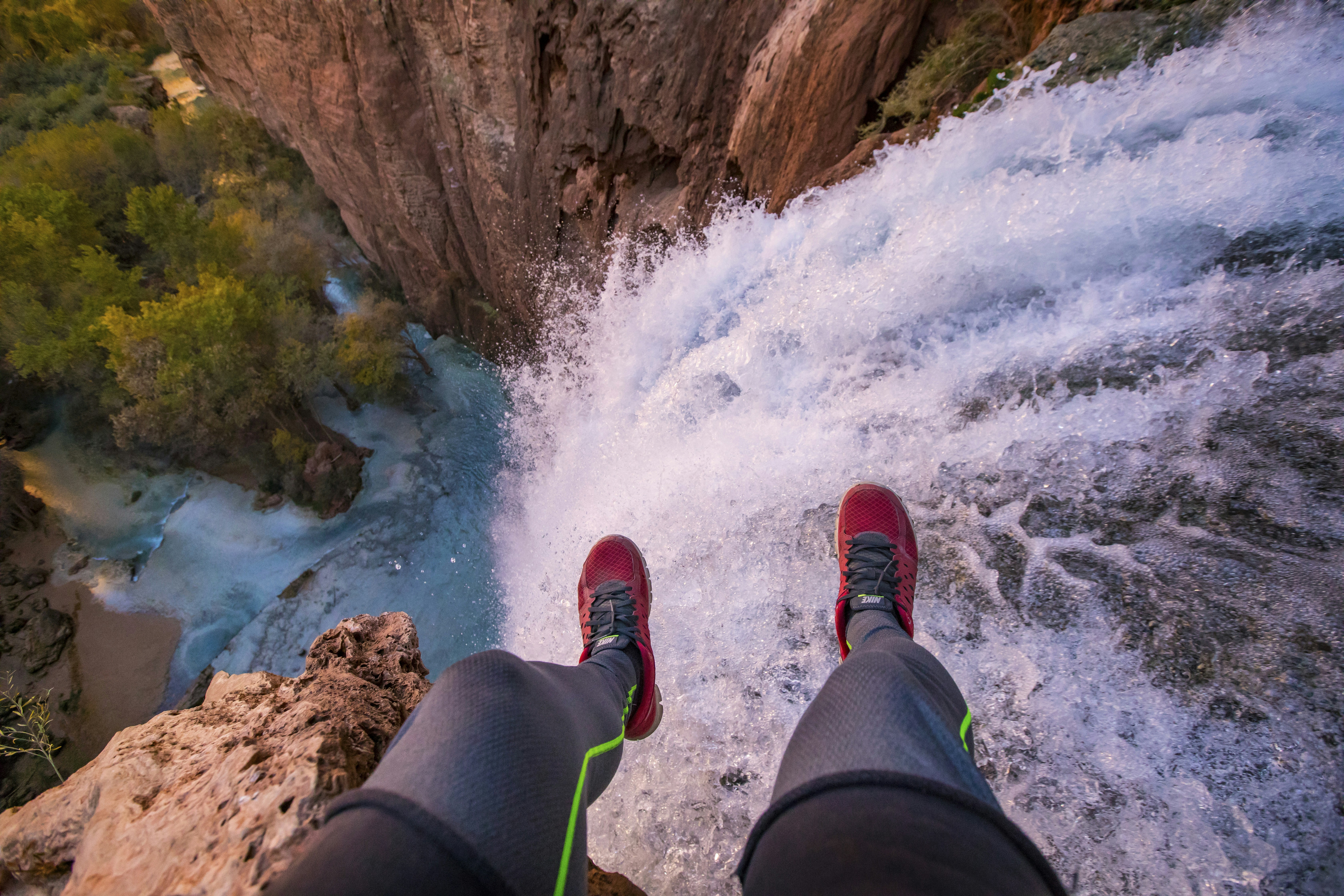 A person standing on top of a waterfall photo – Free Water Image on ...