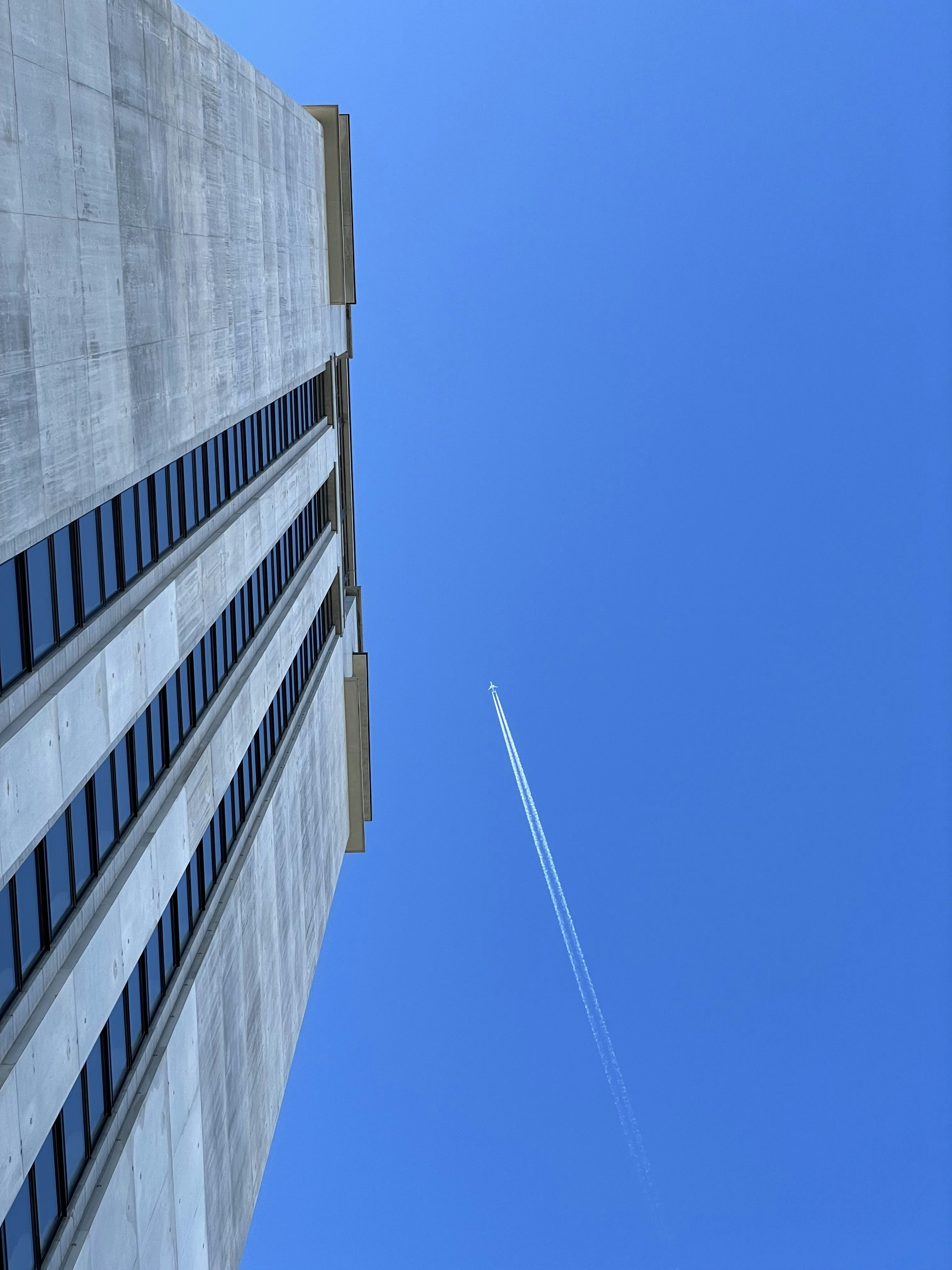 An airplane flying in the sky over a building photo – Free City Image ...
