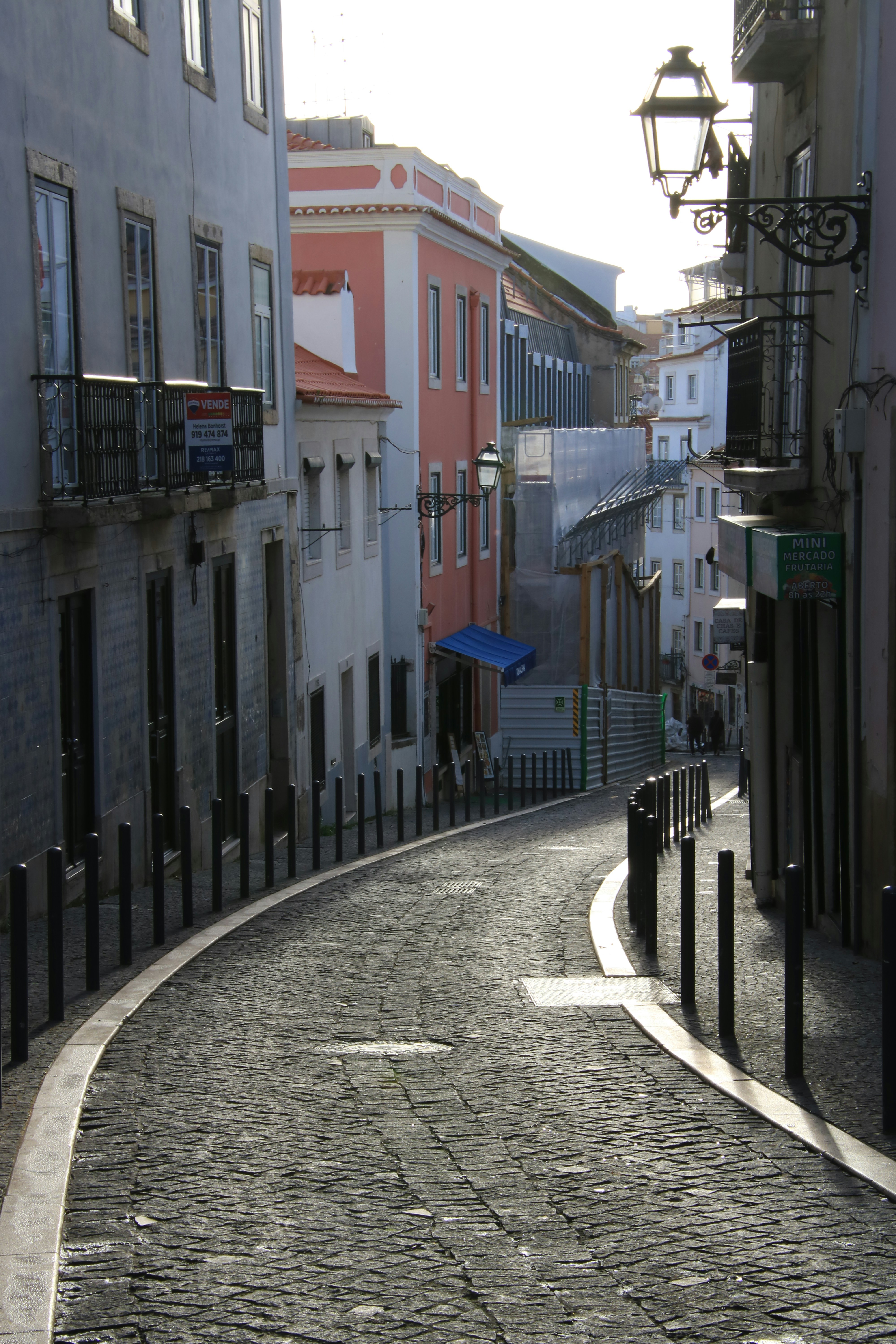 Sunlit Narrow Street Winding Through Colorful Coastal Architecture