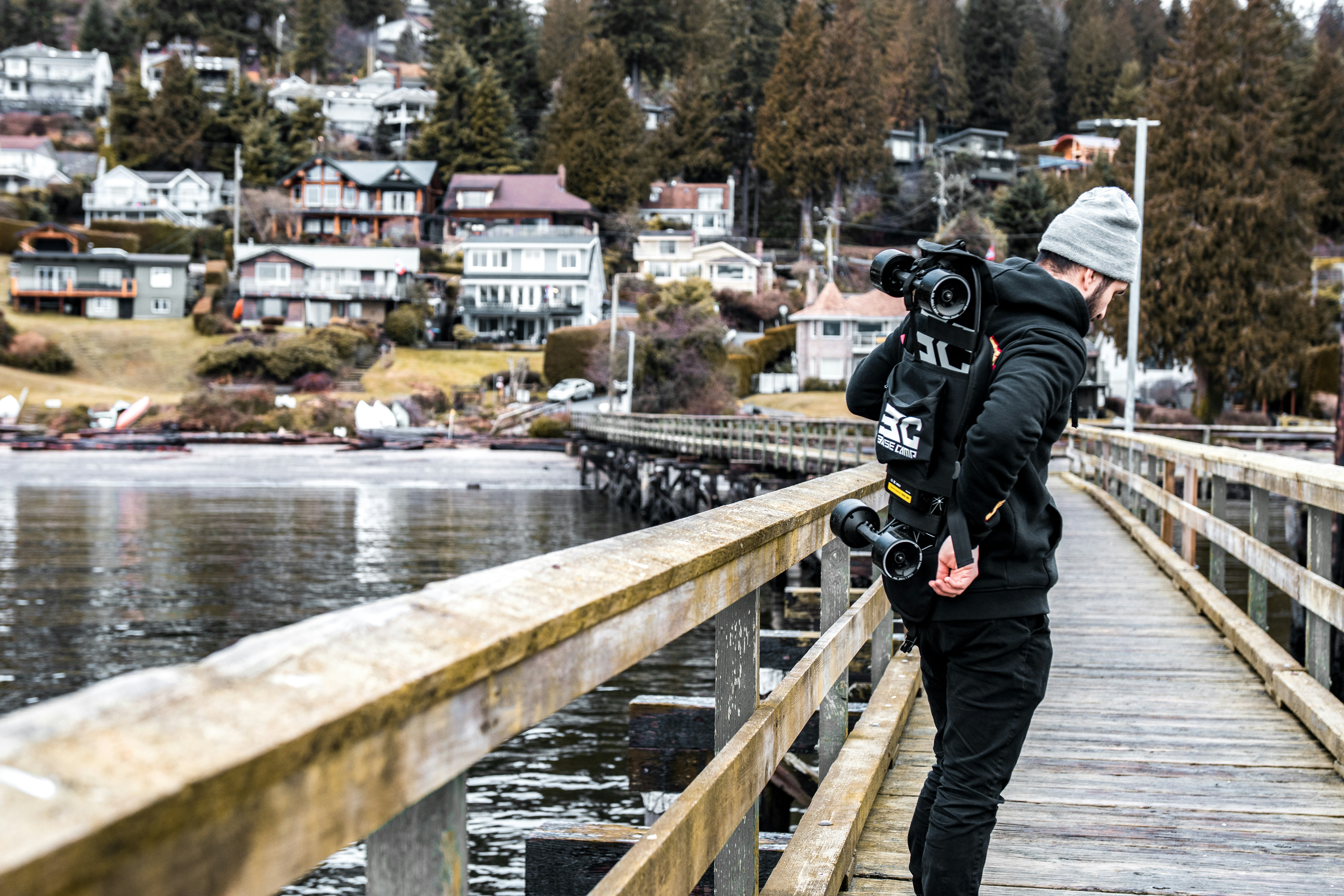 Pier-side Rig: A Photographer Balances Dual Cameras on a Windy Lakeside Boardwalk