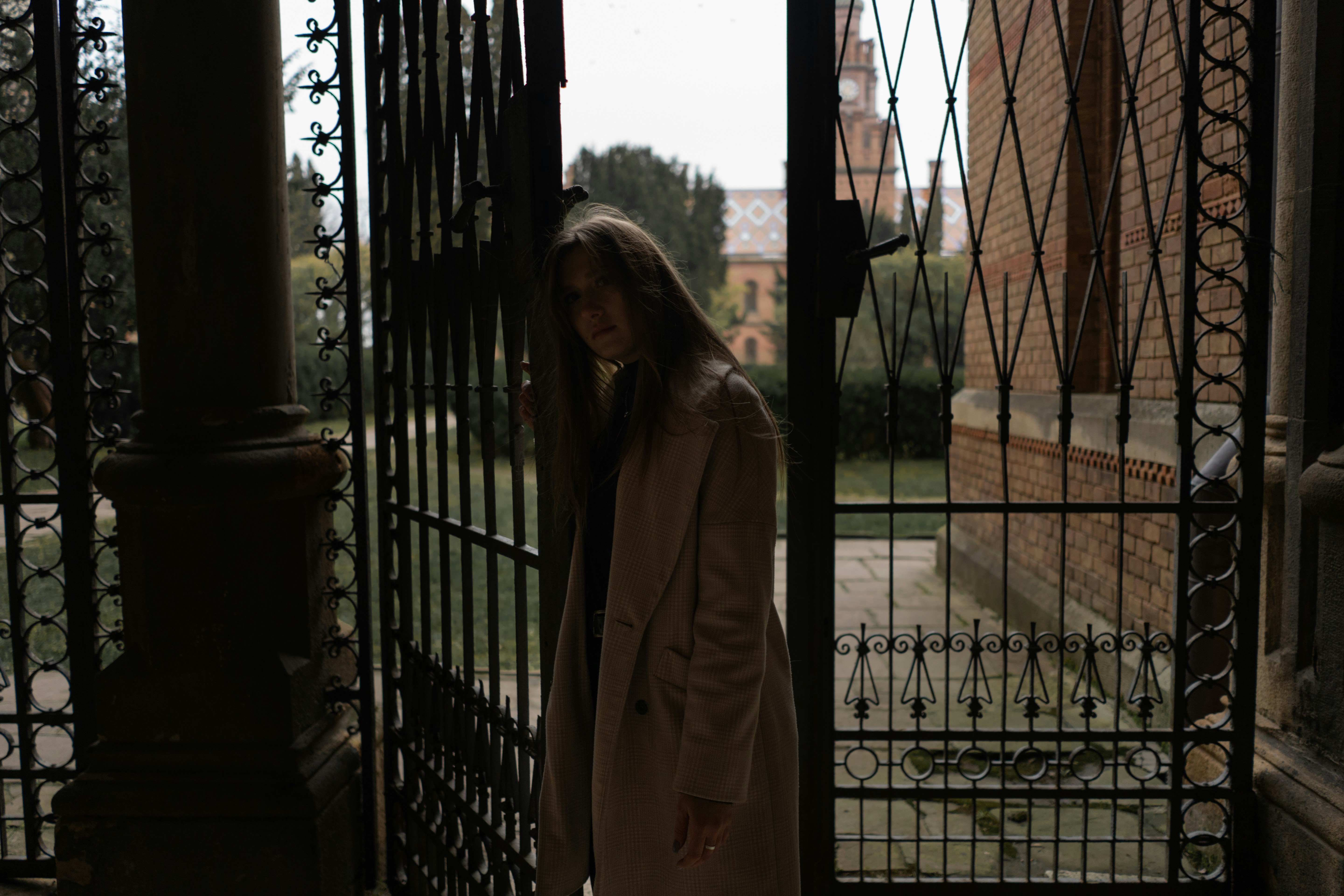 A woman standing in front of a gate photo – Free Chernivtsi Image on ...