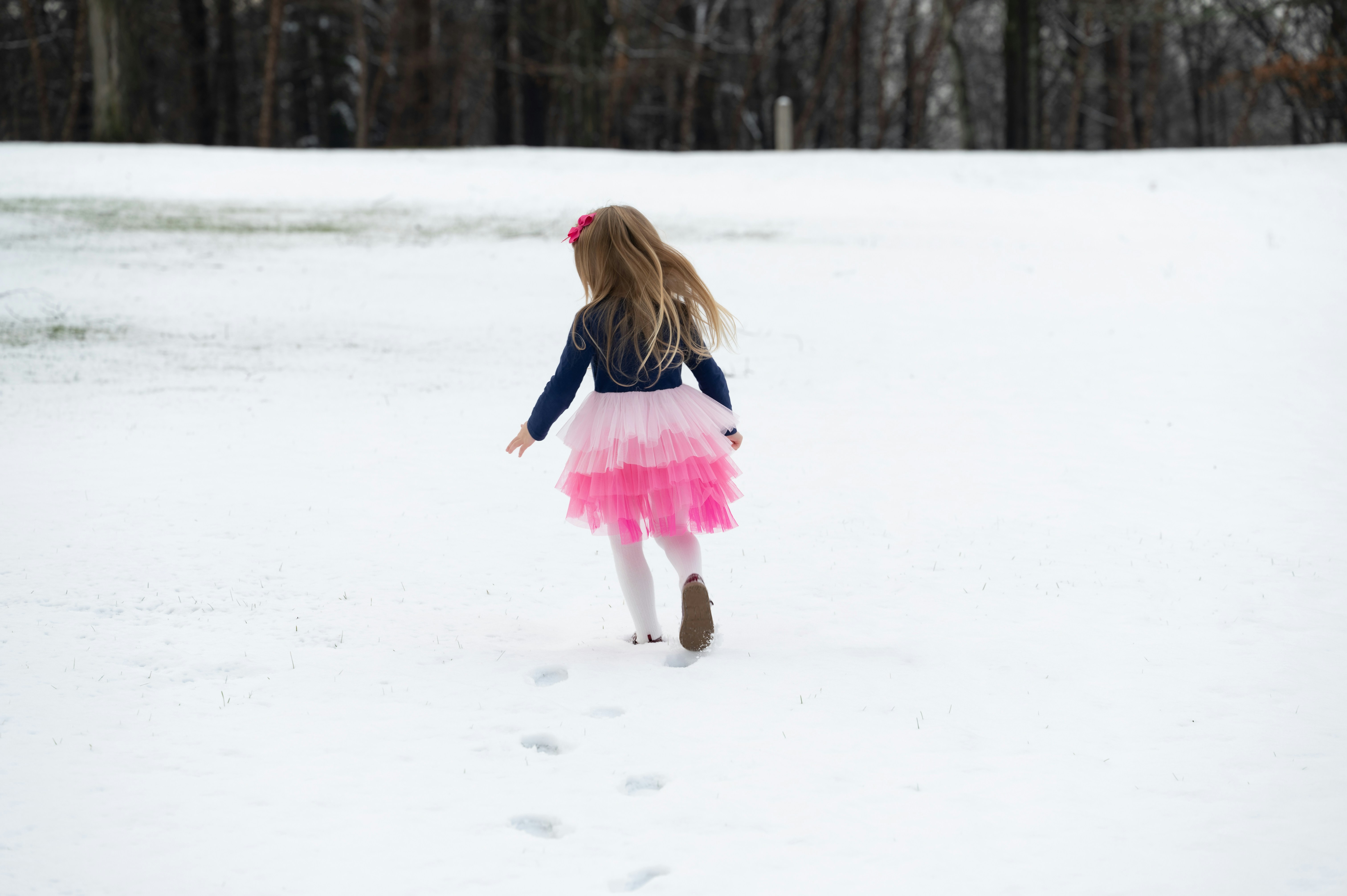 Footprints in Frost: A Little Runner in Pink Tutu Crossing a Quiet Winter Field