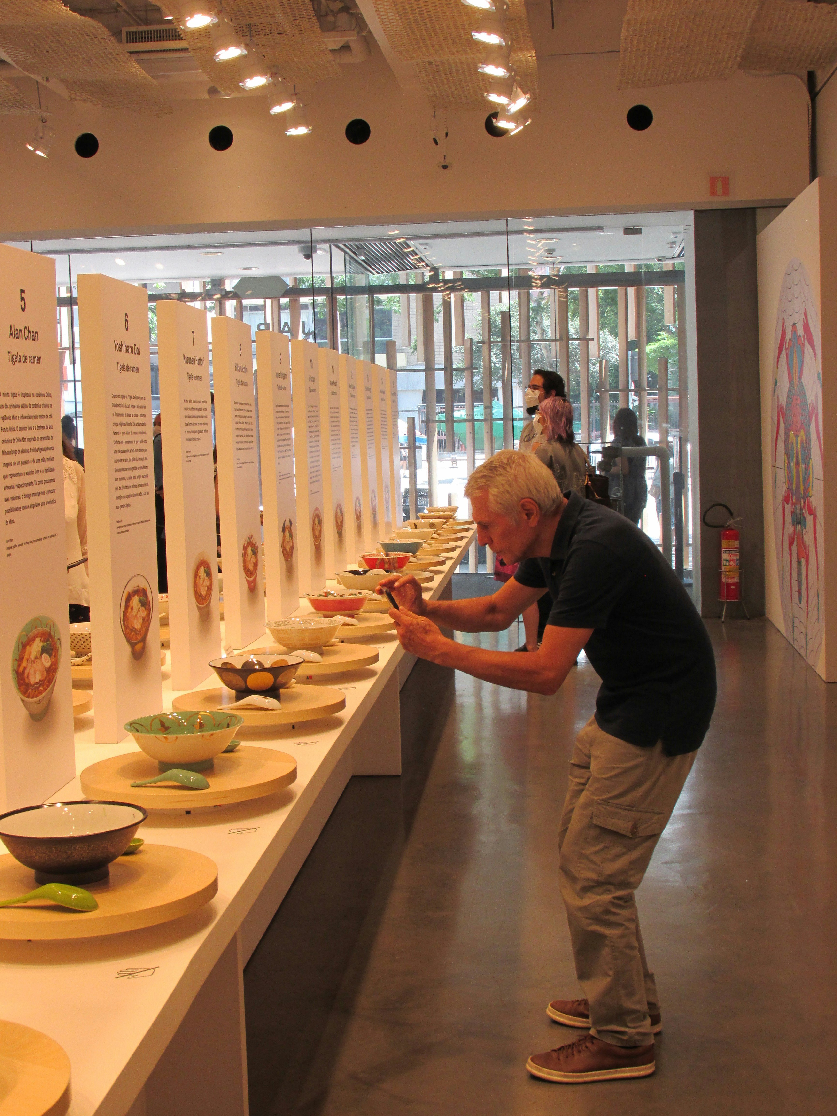 a man standing in front of a row of plates