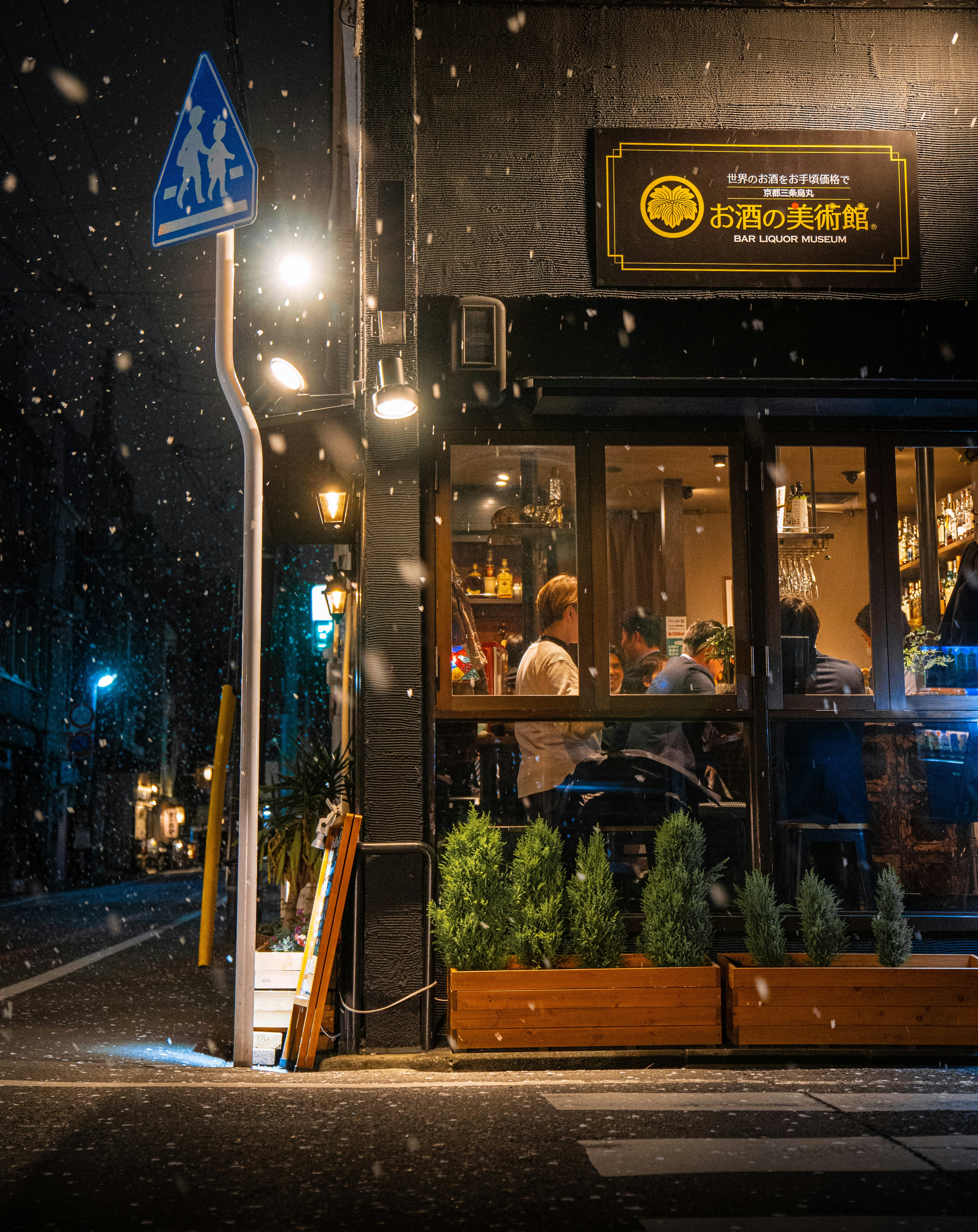 Warm glow from a cozy café on a snowy street at night