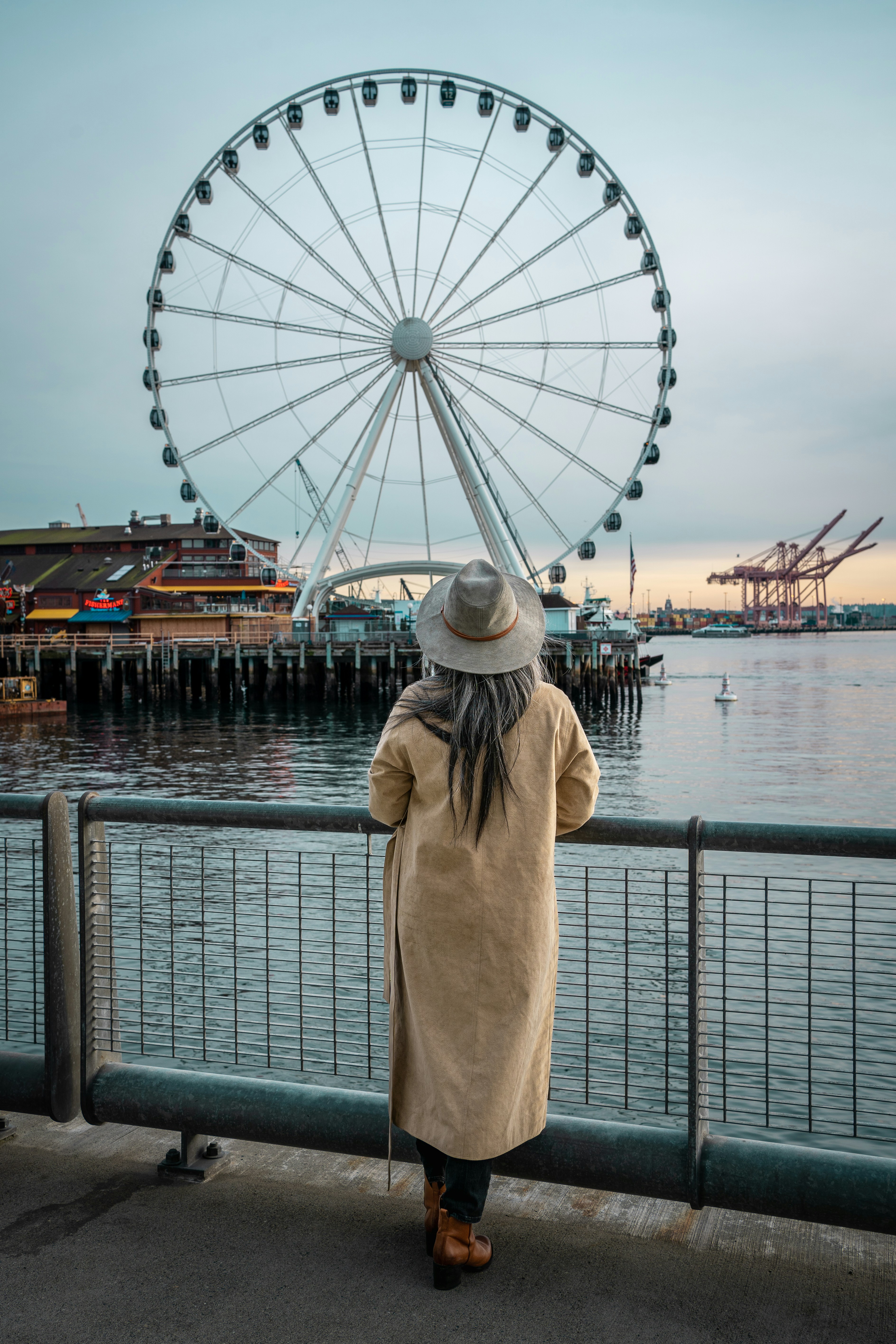 Ferris Wheel Vista: A Woman in Tan by the Waterfront