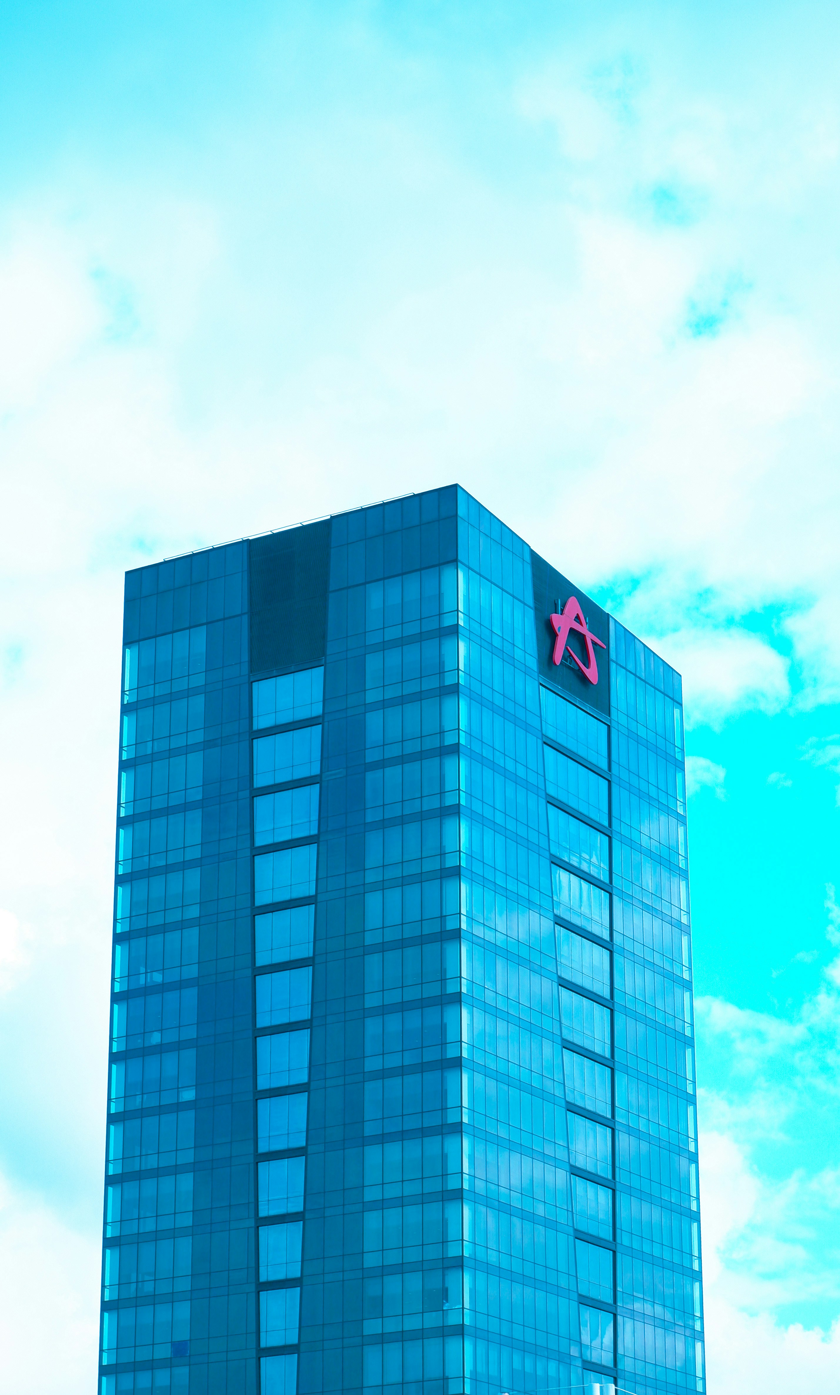 A tall blue building with a red logo on it photo – Free Image on Unsplash