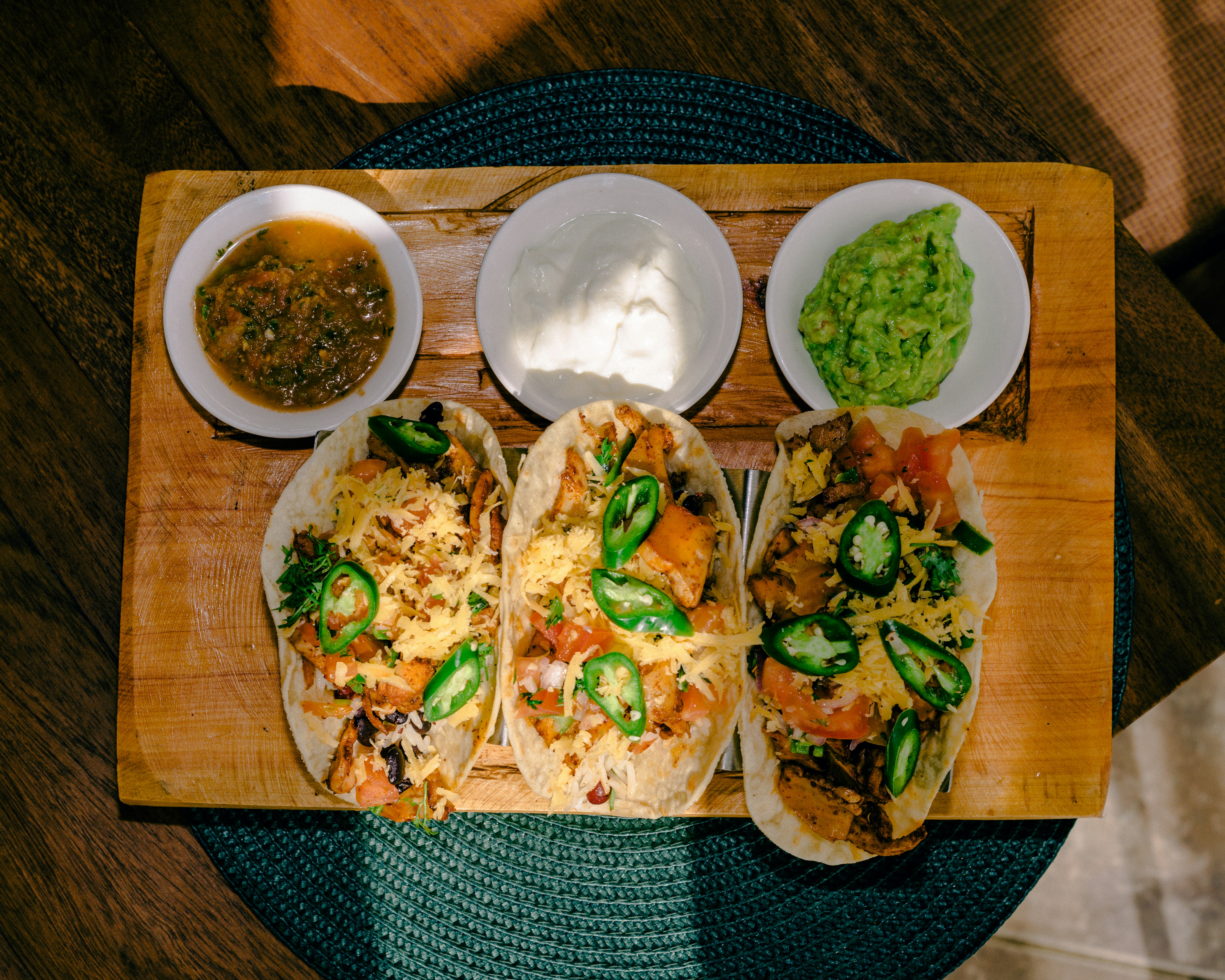Three tacos on a cutting board with salsa and guacamole photo – Free ...