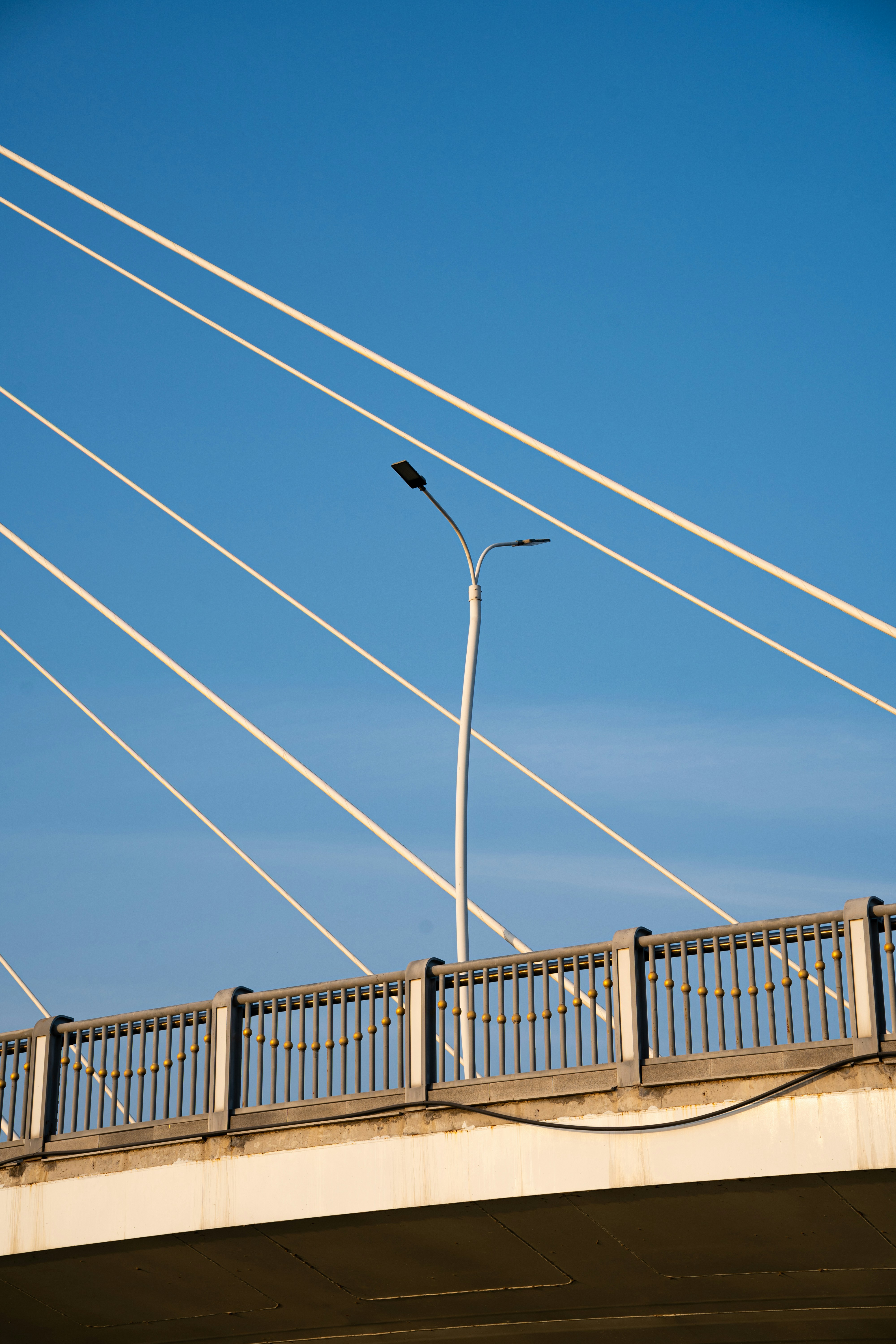 A street light on a bridge with a blue sky in the background photo ...