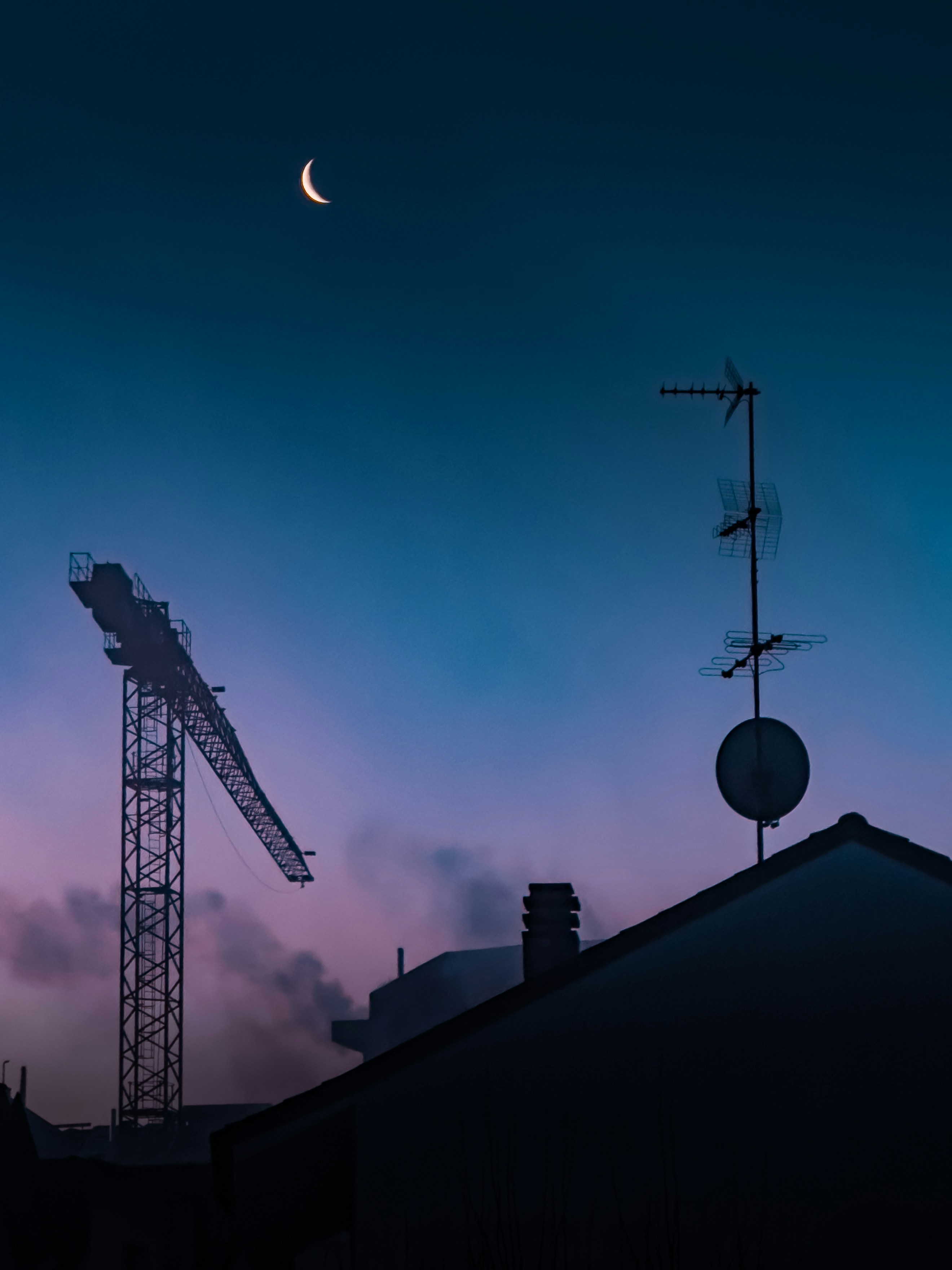 Crescent Moon Over the Rooftop Silhouette at Dusk