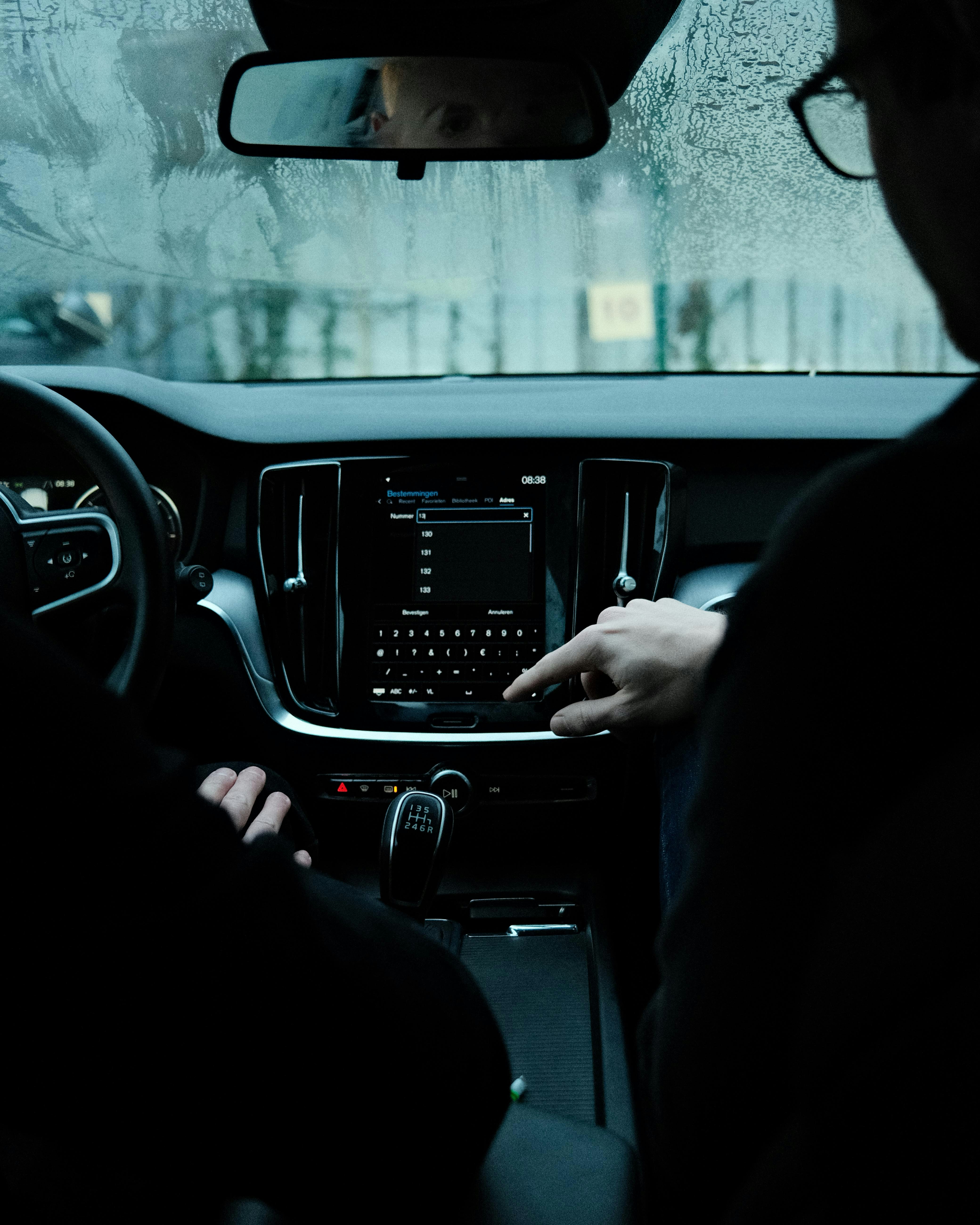 Rain-Streaked Center Console: A Quiet Hands-On Moment in a Modern Cabin