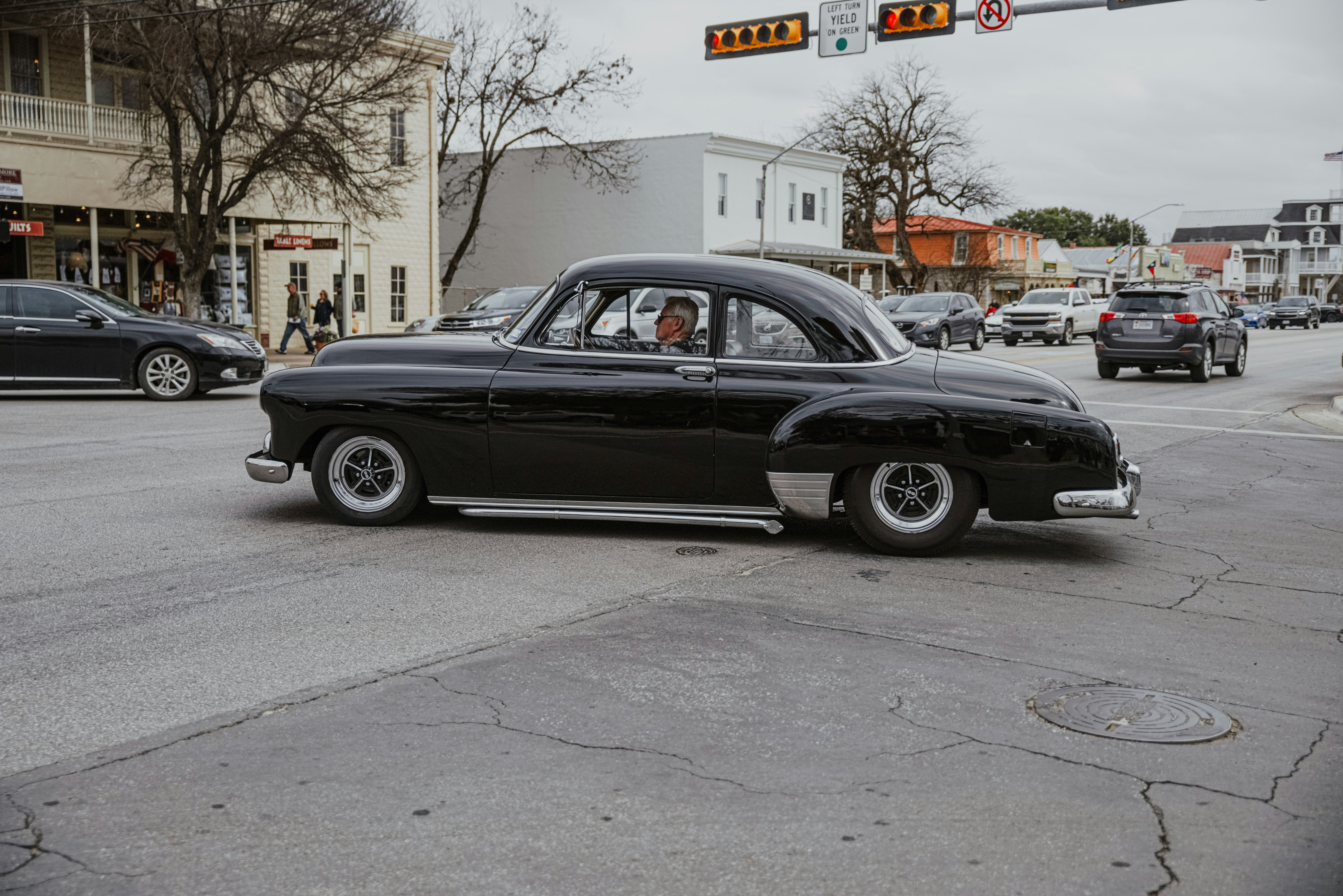 Midnight on Main: A 1950s black coupe crosses a sleepy town intersection