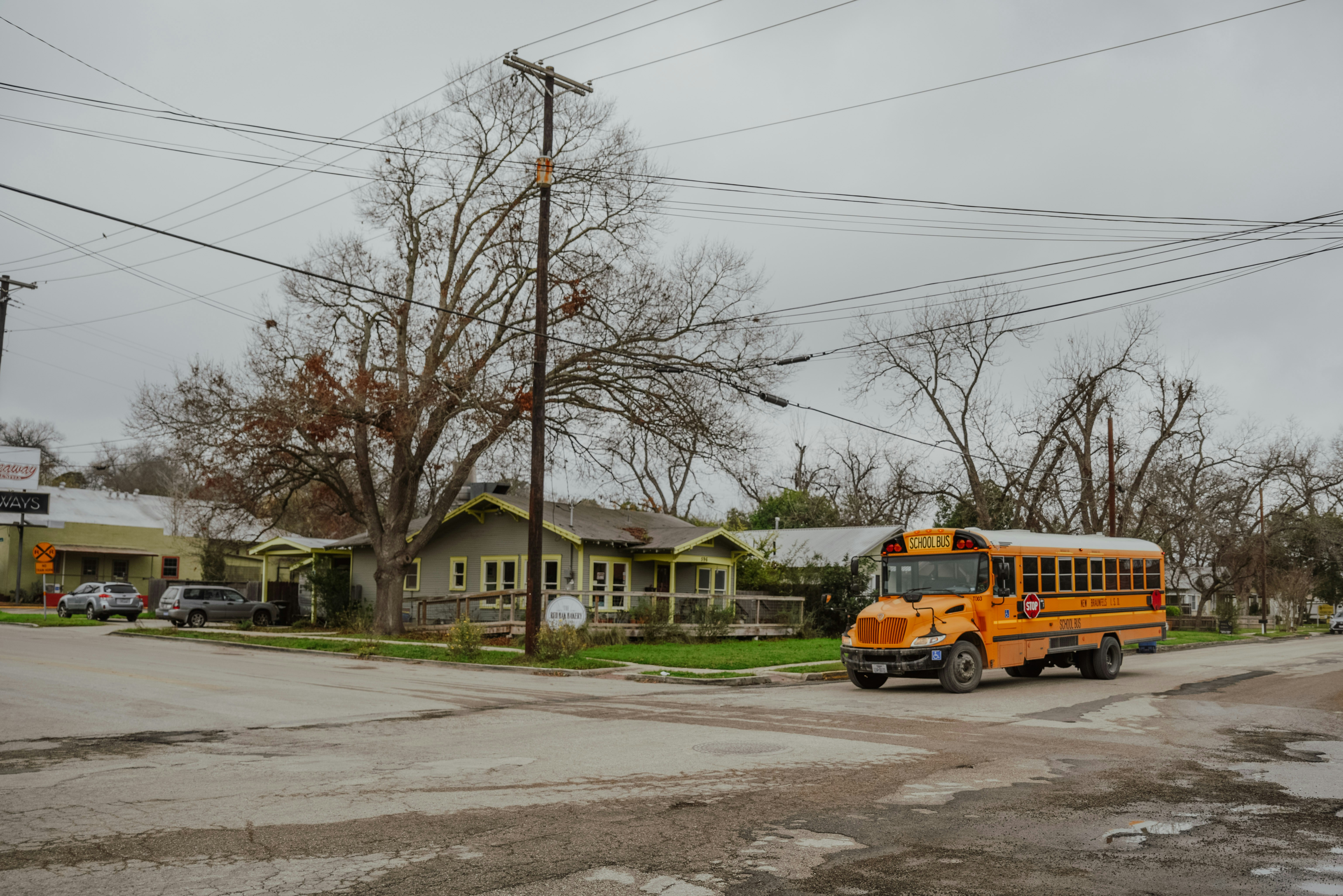 Crossing Quiet: A Yellow School Bus at a Gray Suburban Intersection