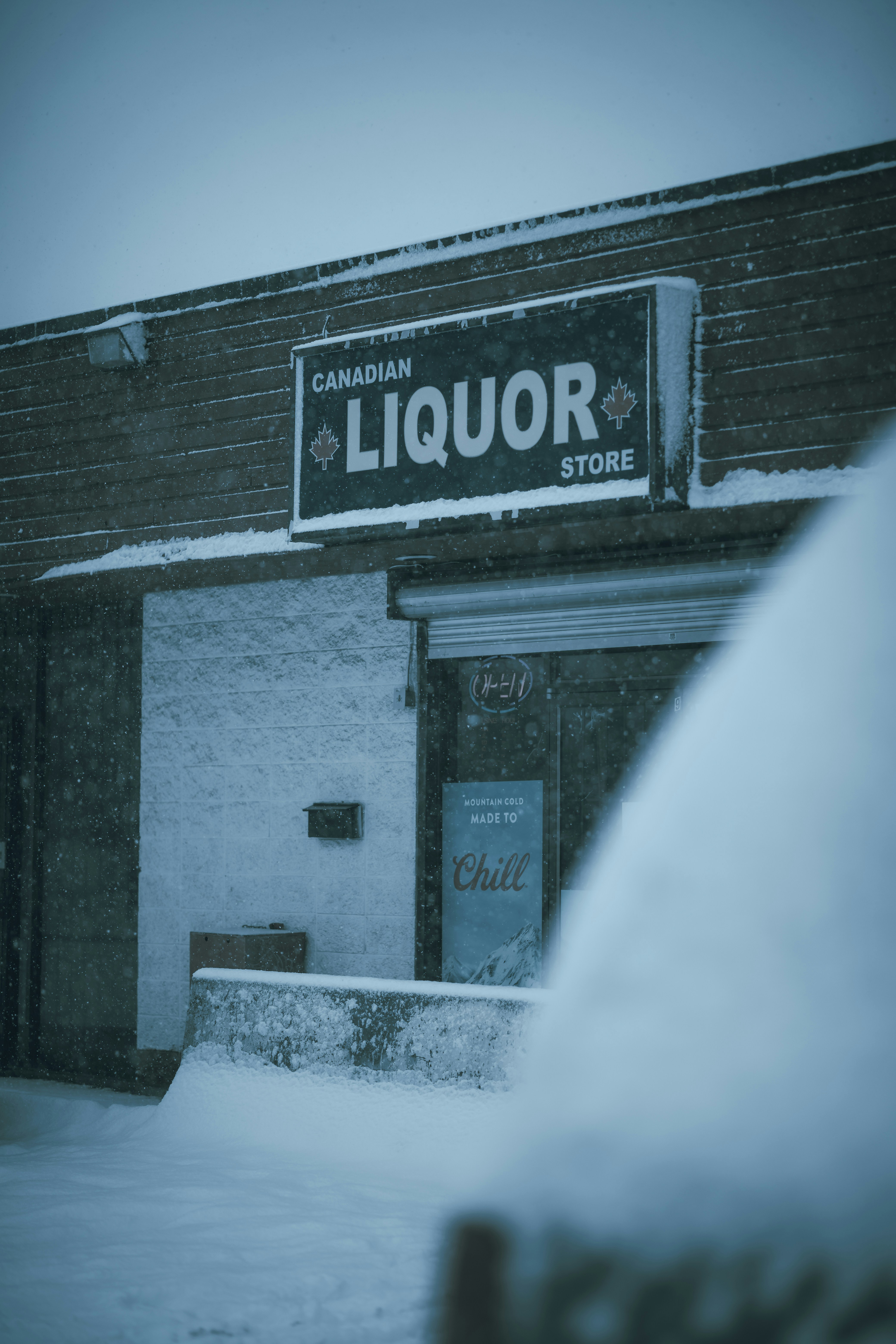 Blue Winter Drift Framing a Canadian Liquor Store Sign