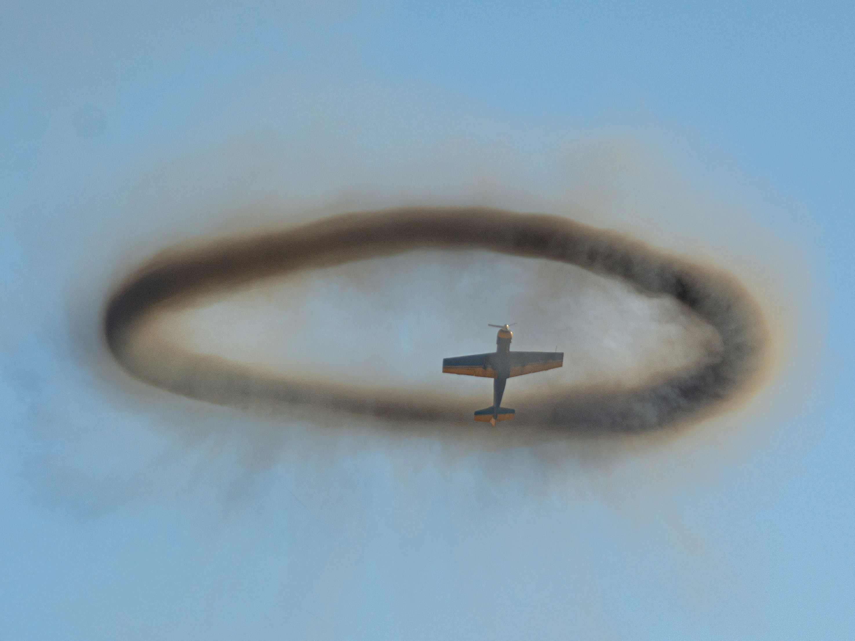 A plane flying in the sky with smoke coming out of it photo – Free ...