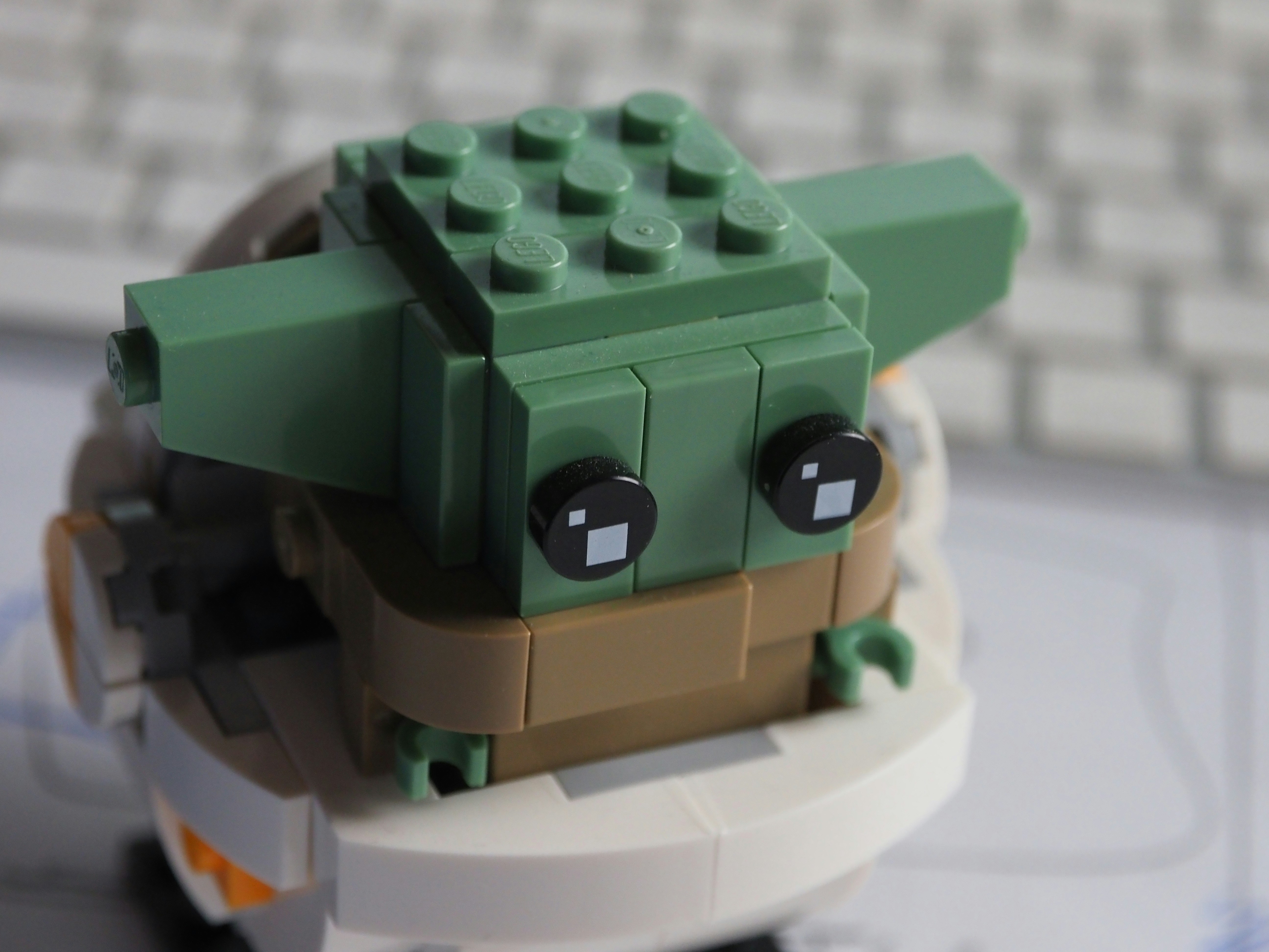 Detailed LEGO figure resembling a popular character with oversized ears and expressive eyes, set against a neutral background.