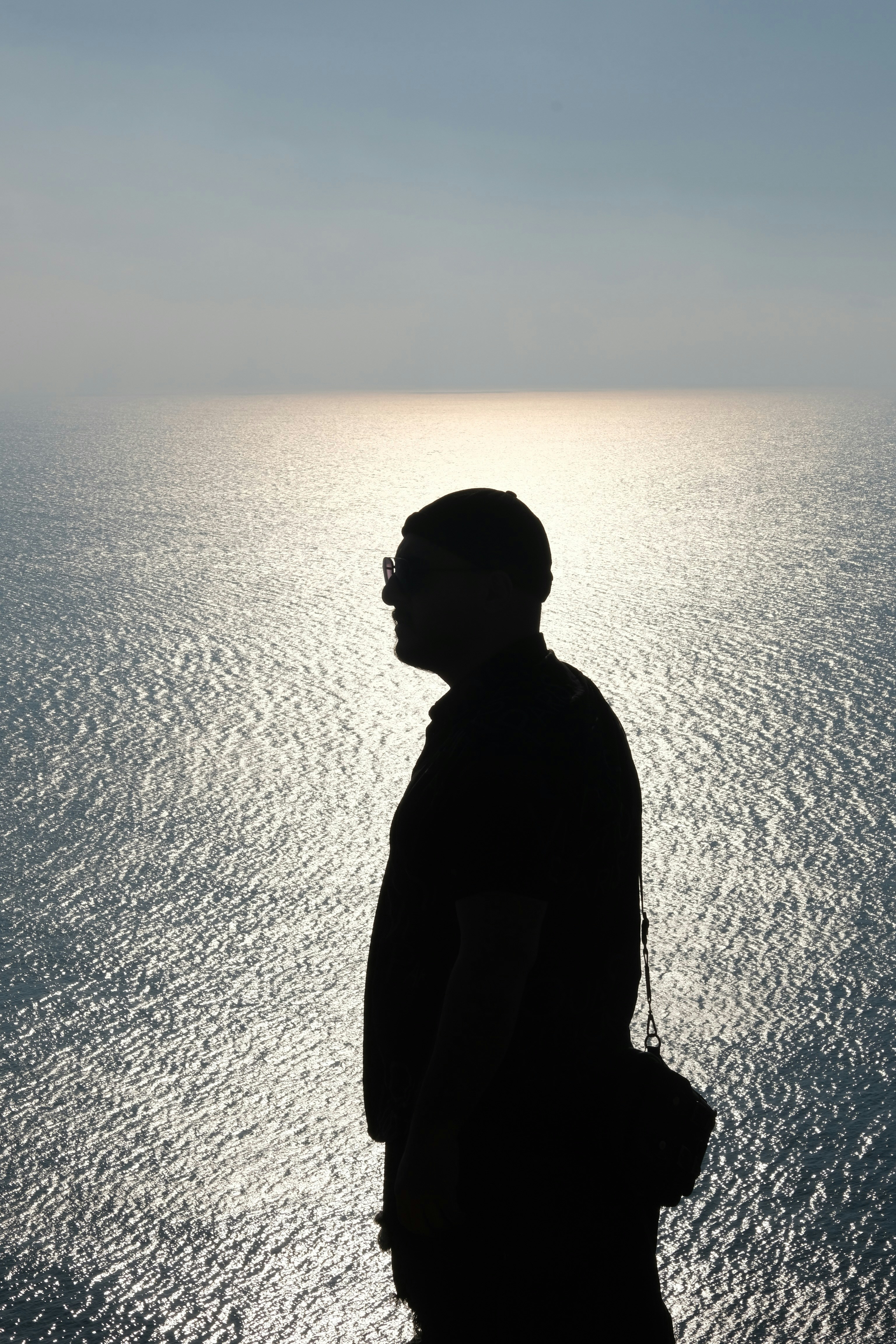 a man standing in front of a body of water