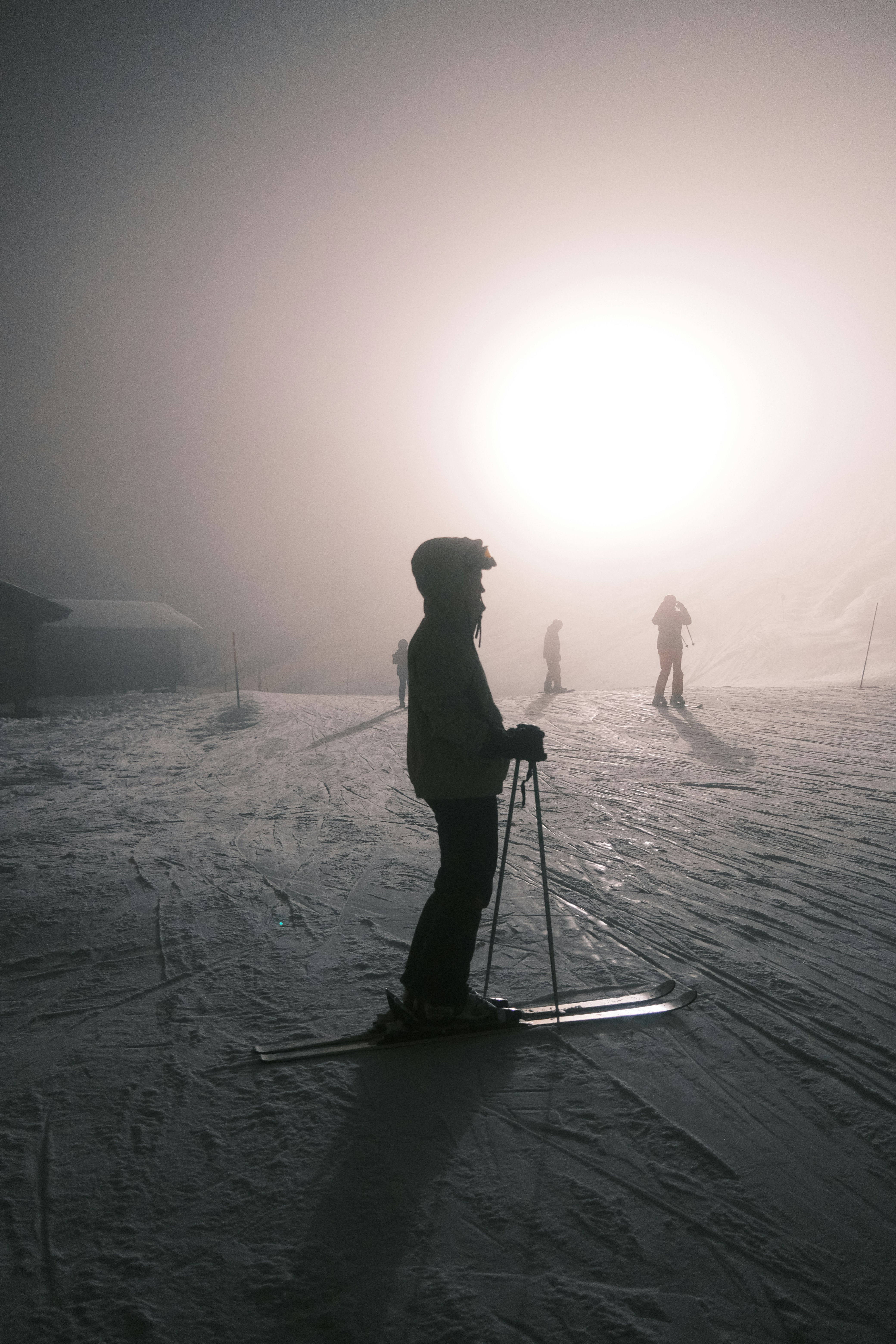 Backlit Silence: A Lone Skier on a Fog-Washed Slope