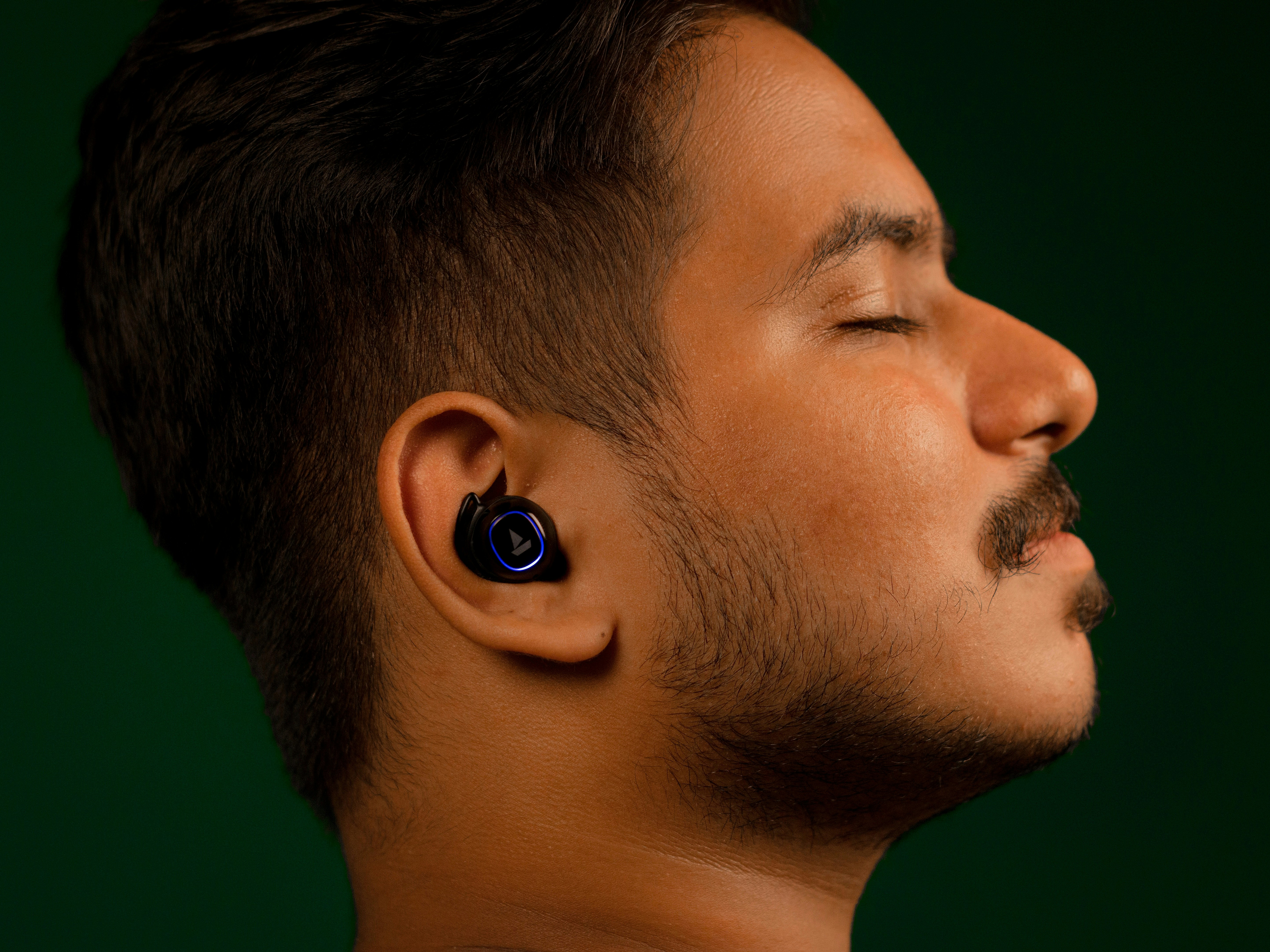 A man wearing a pair of blue ear buds photo – Free Person Image on Unsplash