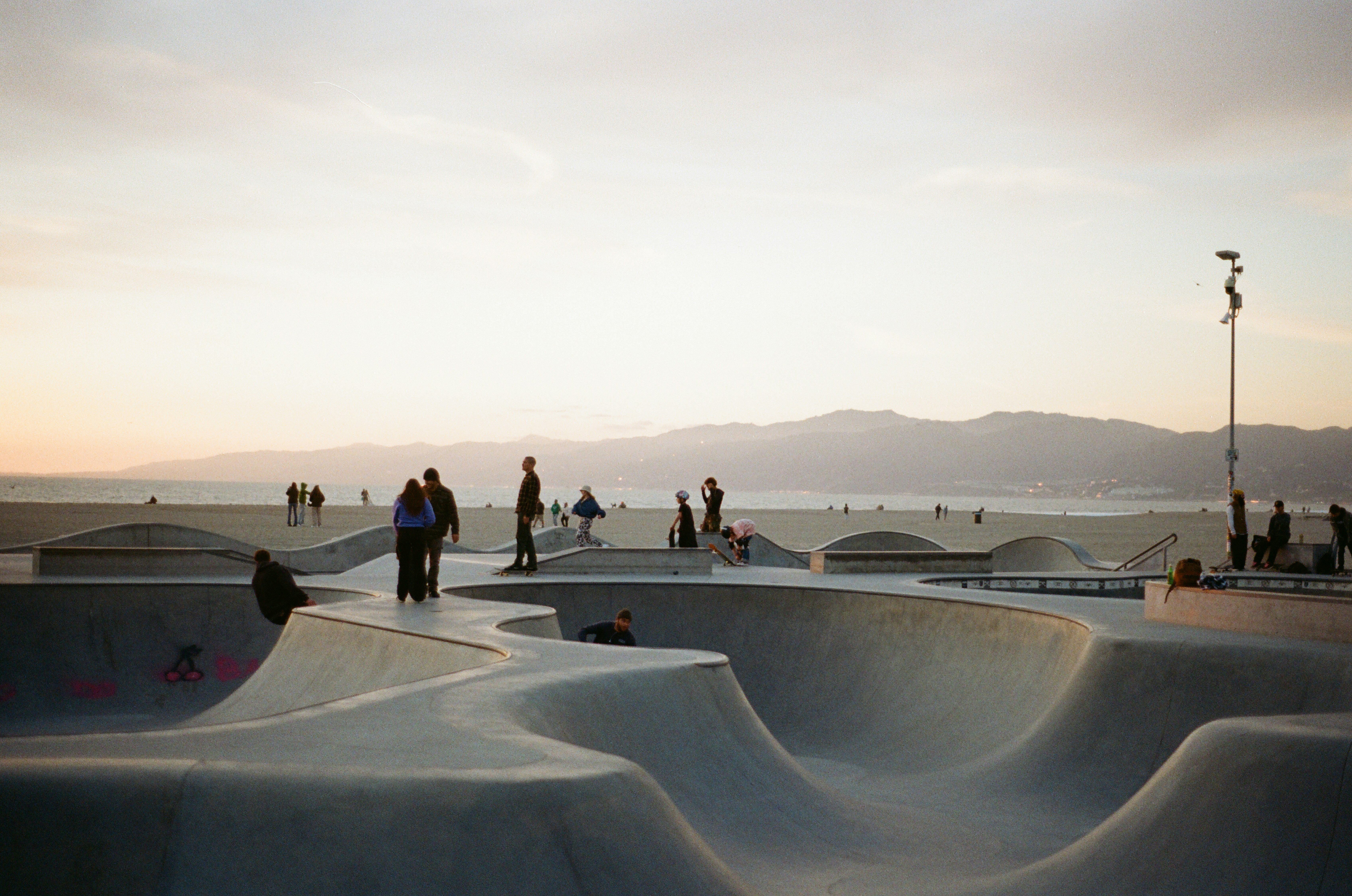 A group of people standing around a skate park photo – Free United ...