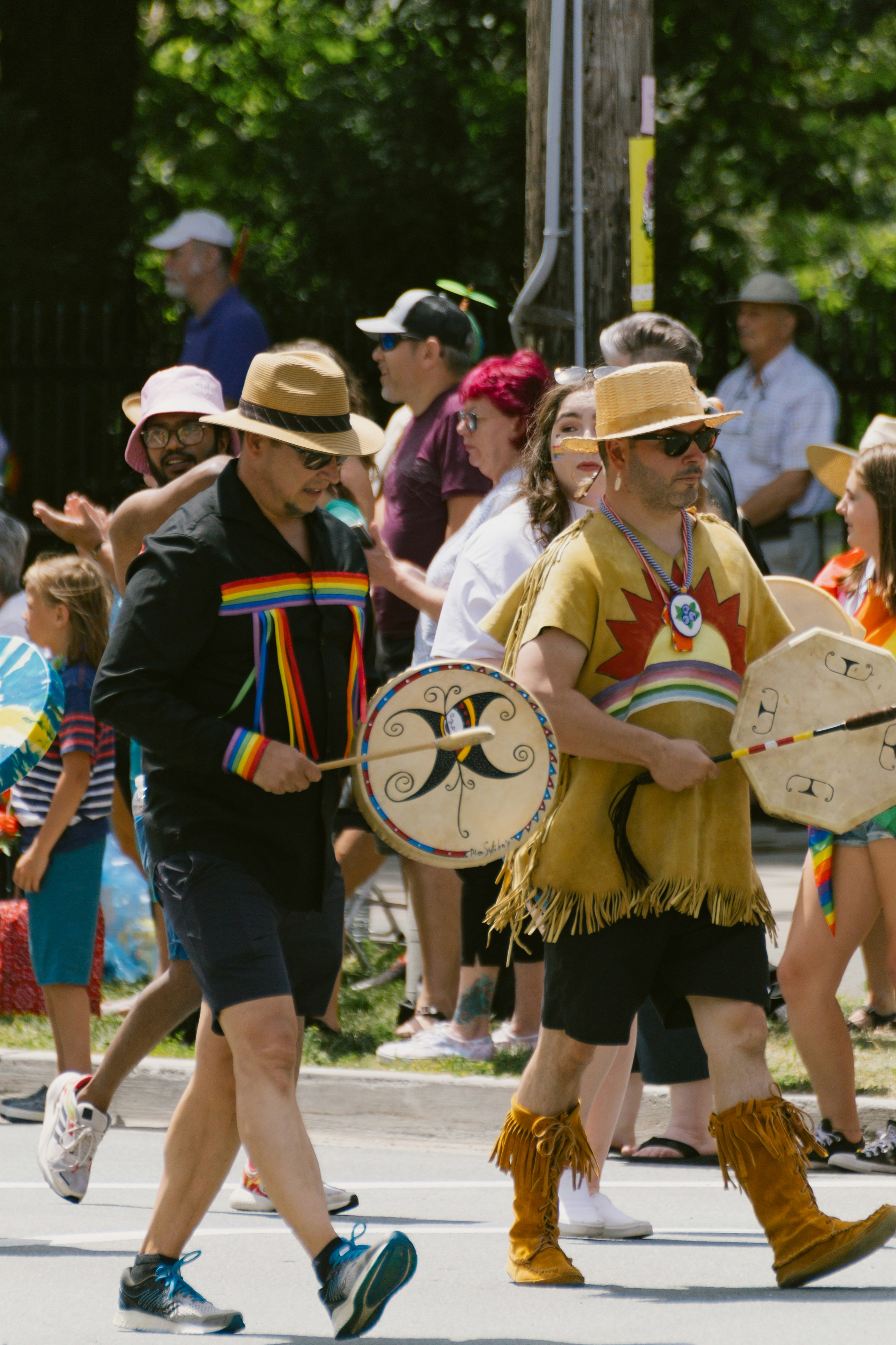 Drummers in a festive parade stride forward in warm sun