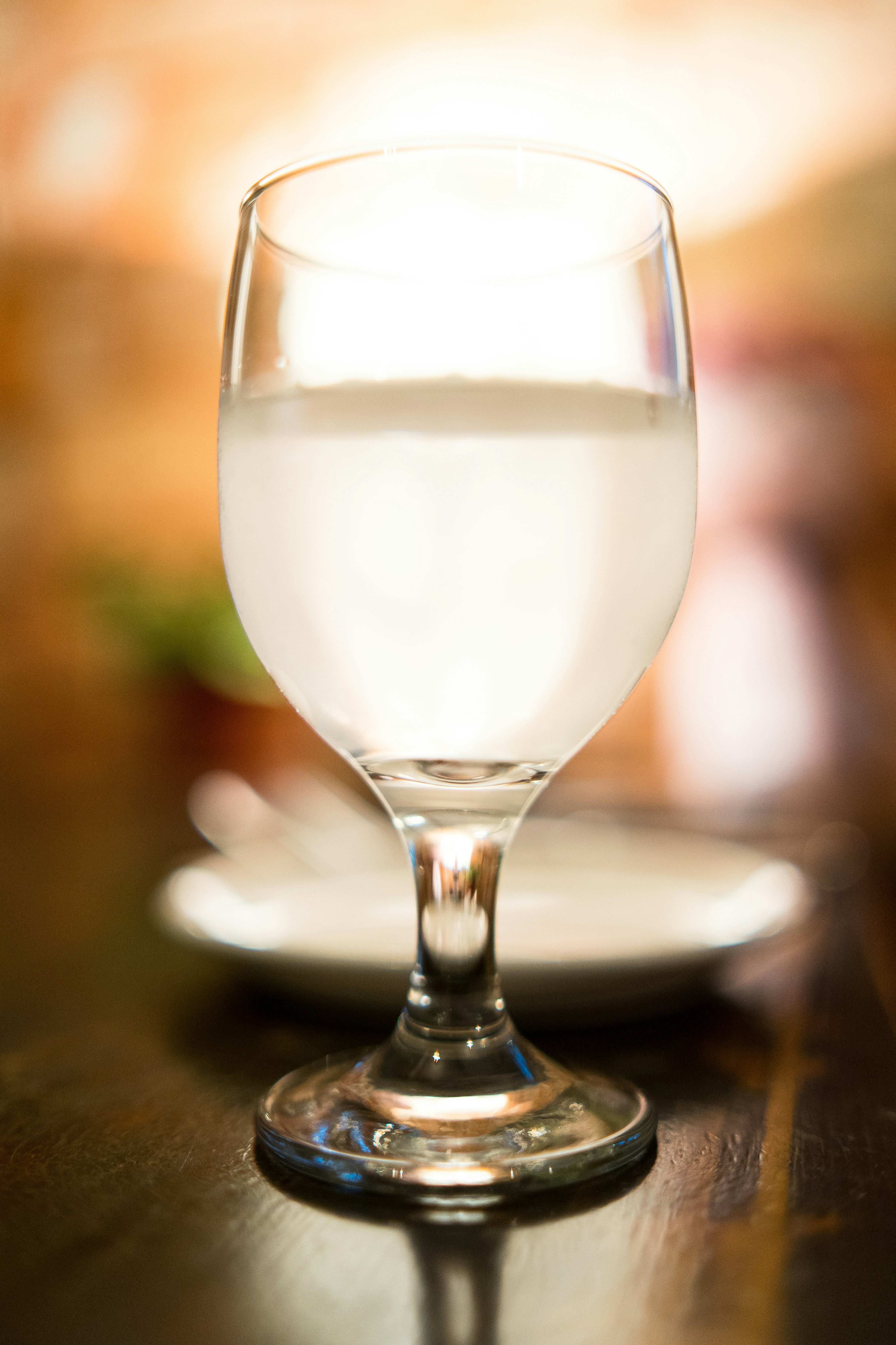 a glass of water sitting on top of a wooden table