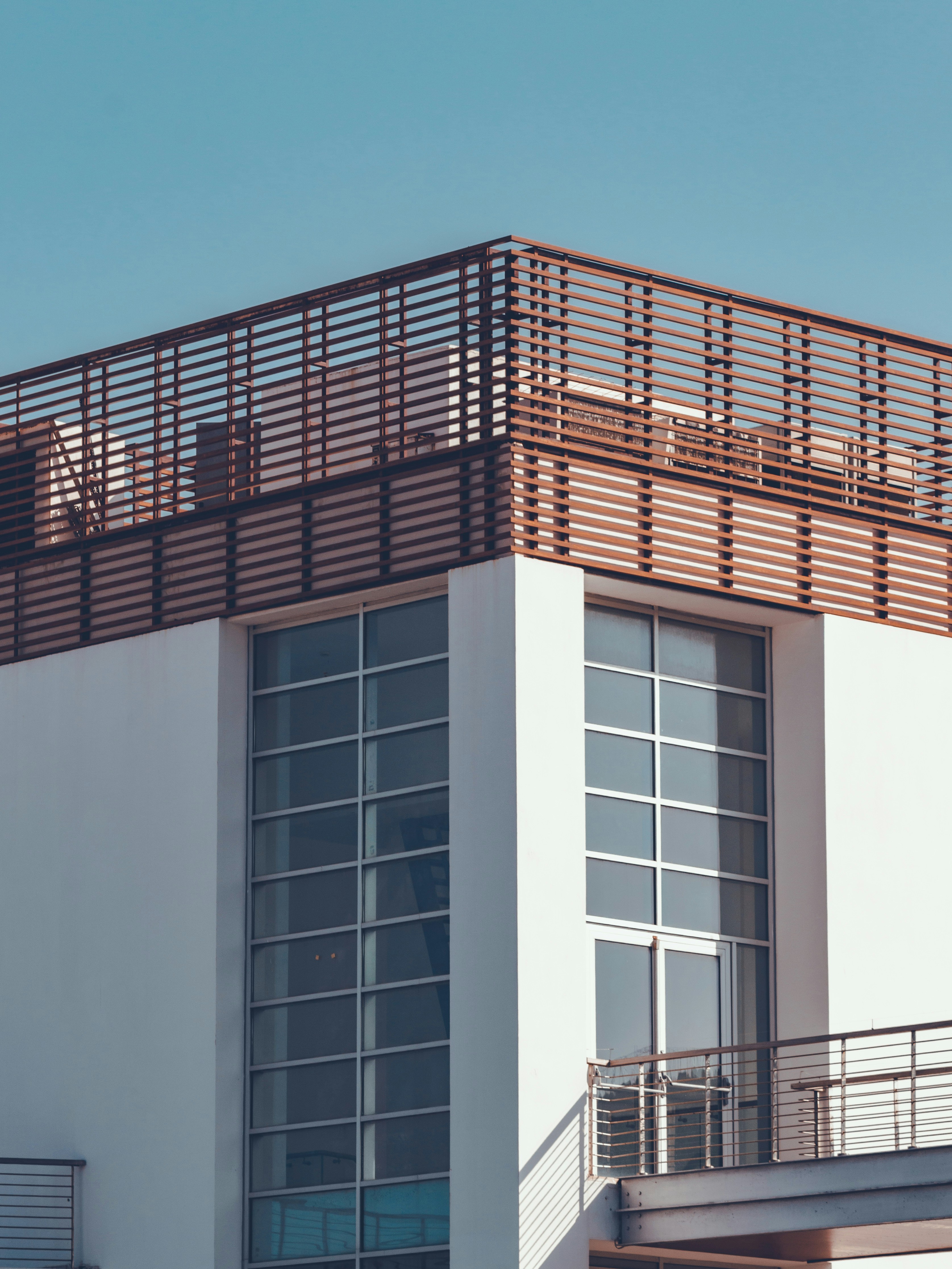 Architectural Terrace: Wood Lattice Above a Modern Glass Facade
