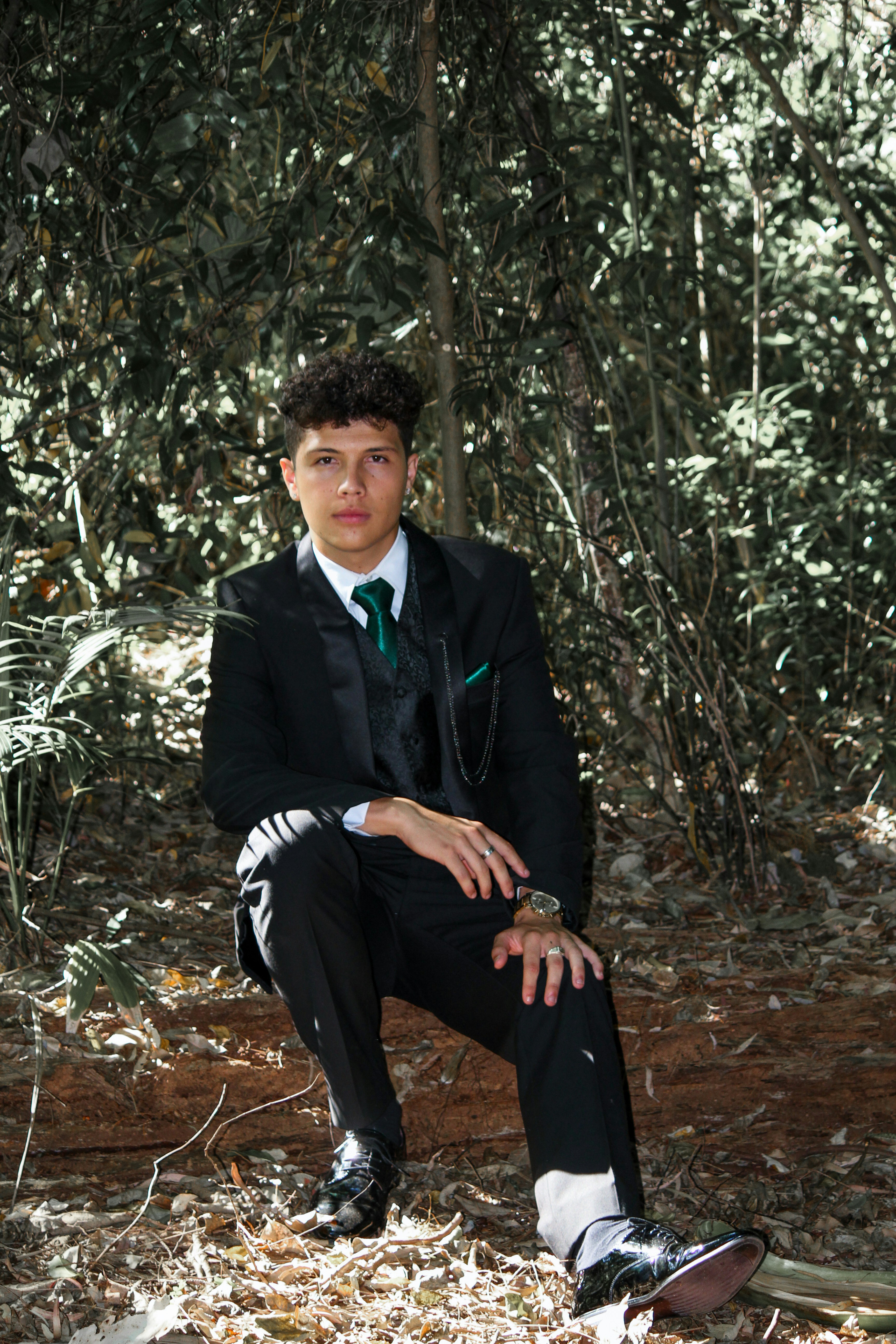 A young man in a suit sitting in the woods photo – Free Forest Image on ...