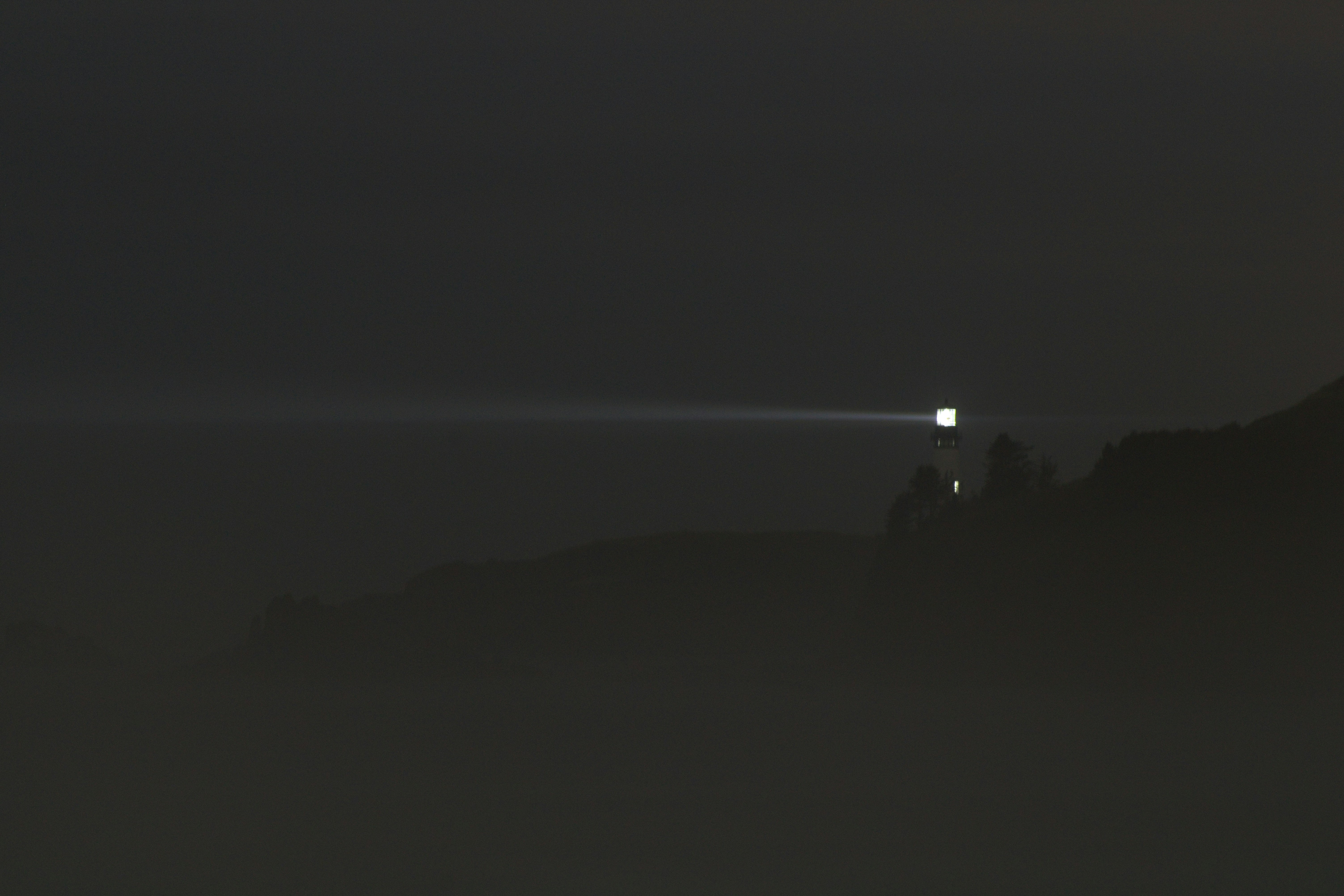 A foggy night with a light in the distance photo – Free Yaquina head ...