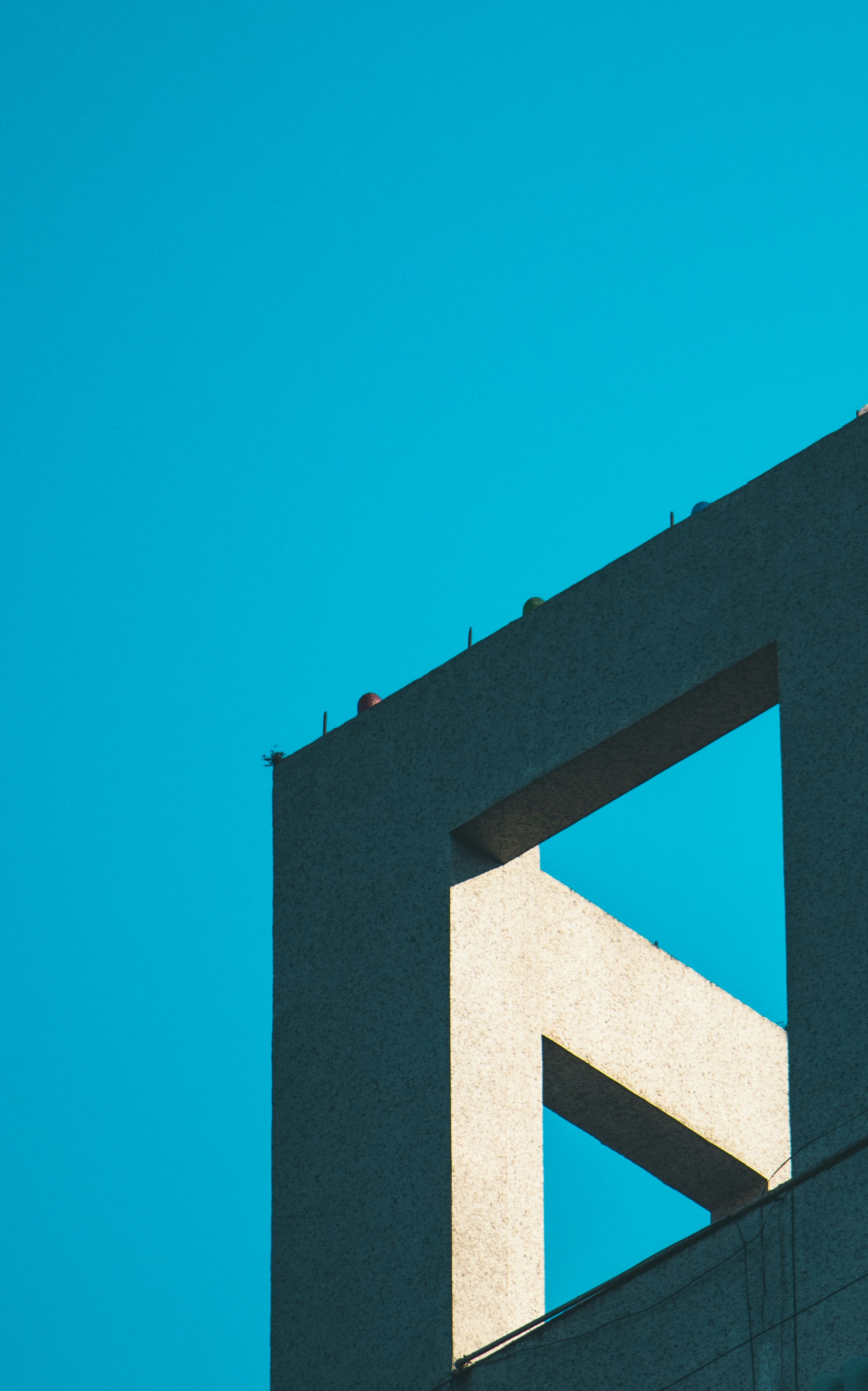 Framed Geometry: A Concrete Window Cut Against Ultramarine Sky