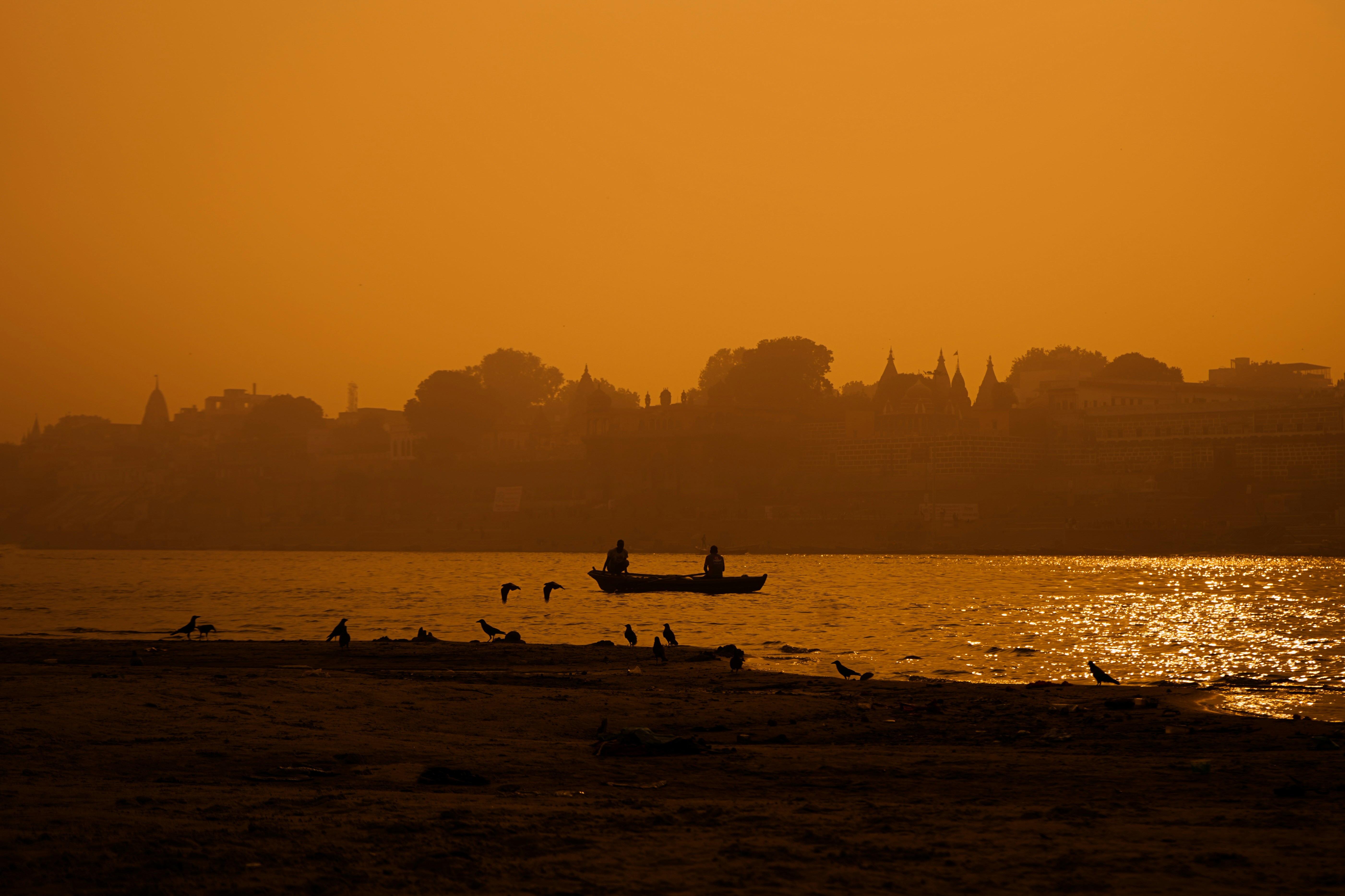 A boat sailing in the Ganges River in Varanasi, India during golden hour.