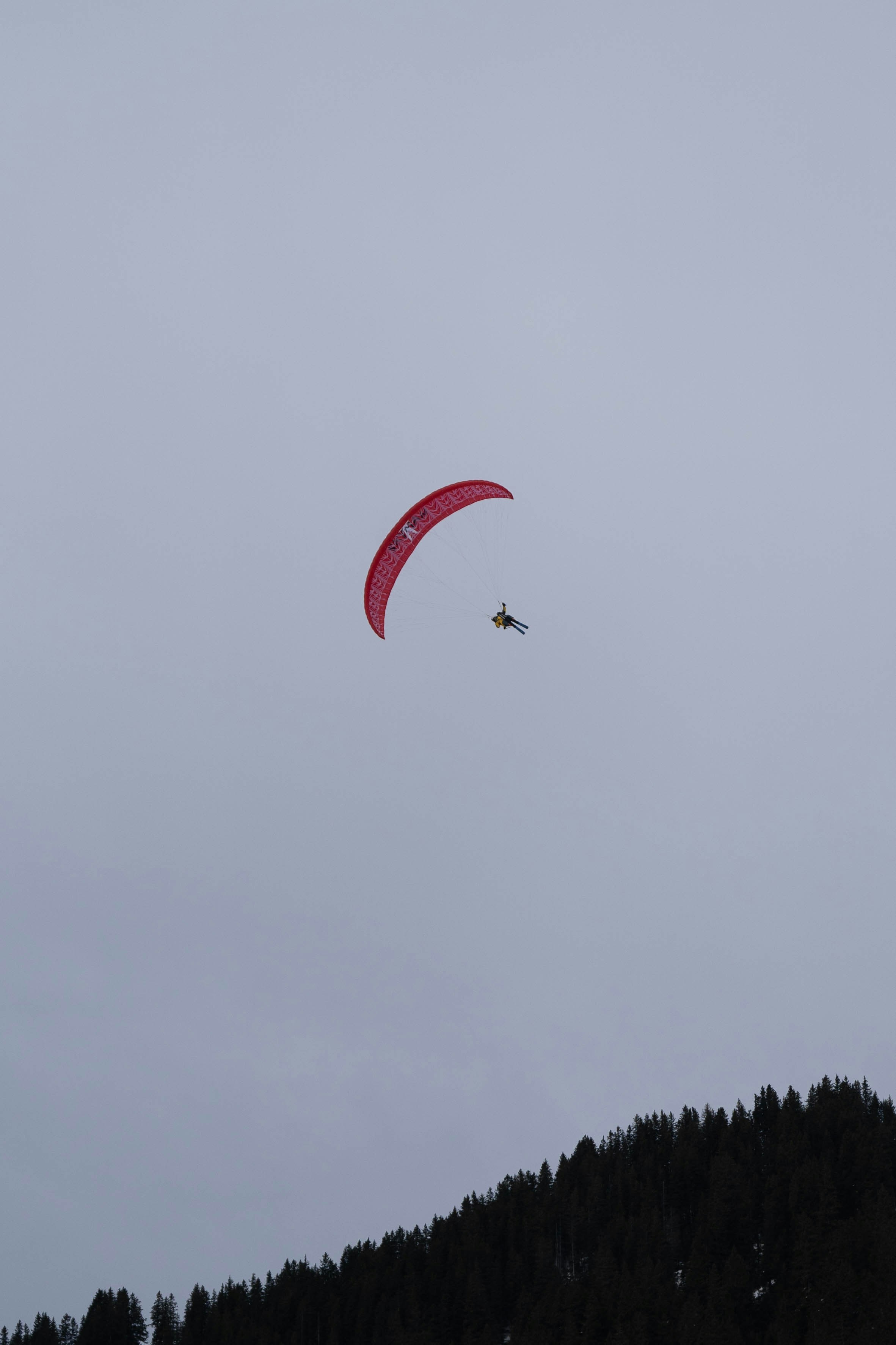 a paraglider is flying through the air over a mountain