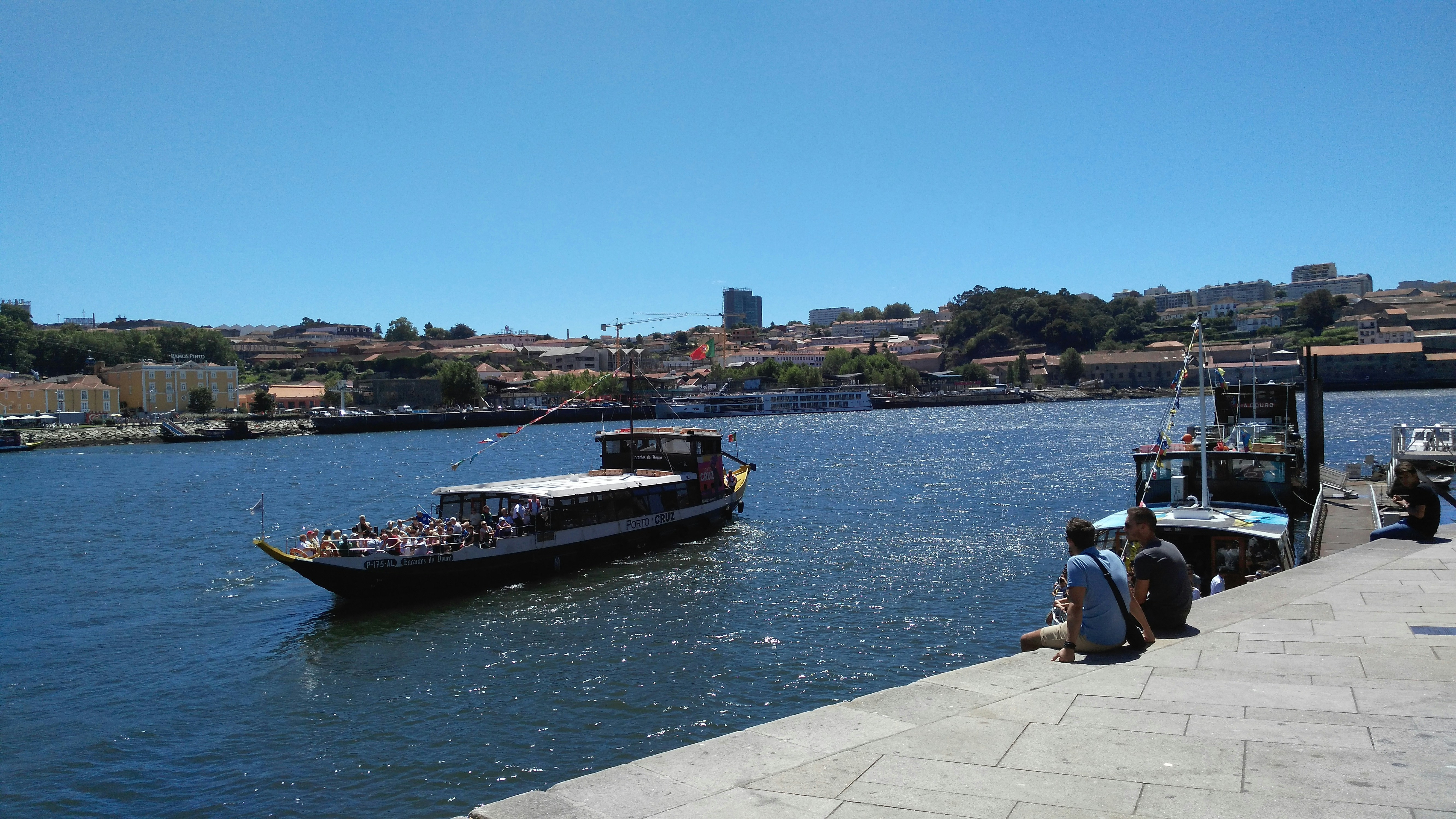 Quayside Momentum: A Boat Glides Through Blue Harbor Toward the Distant City
