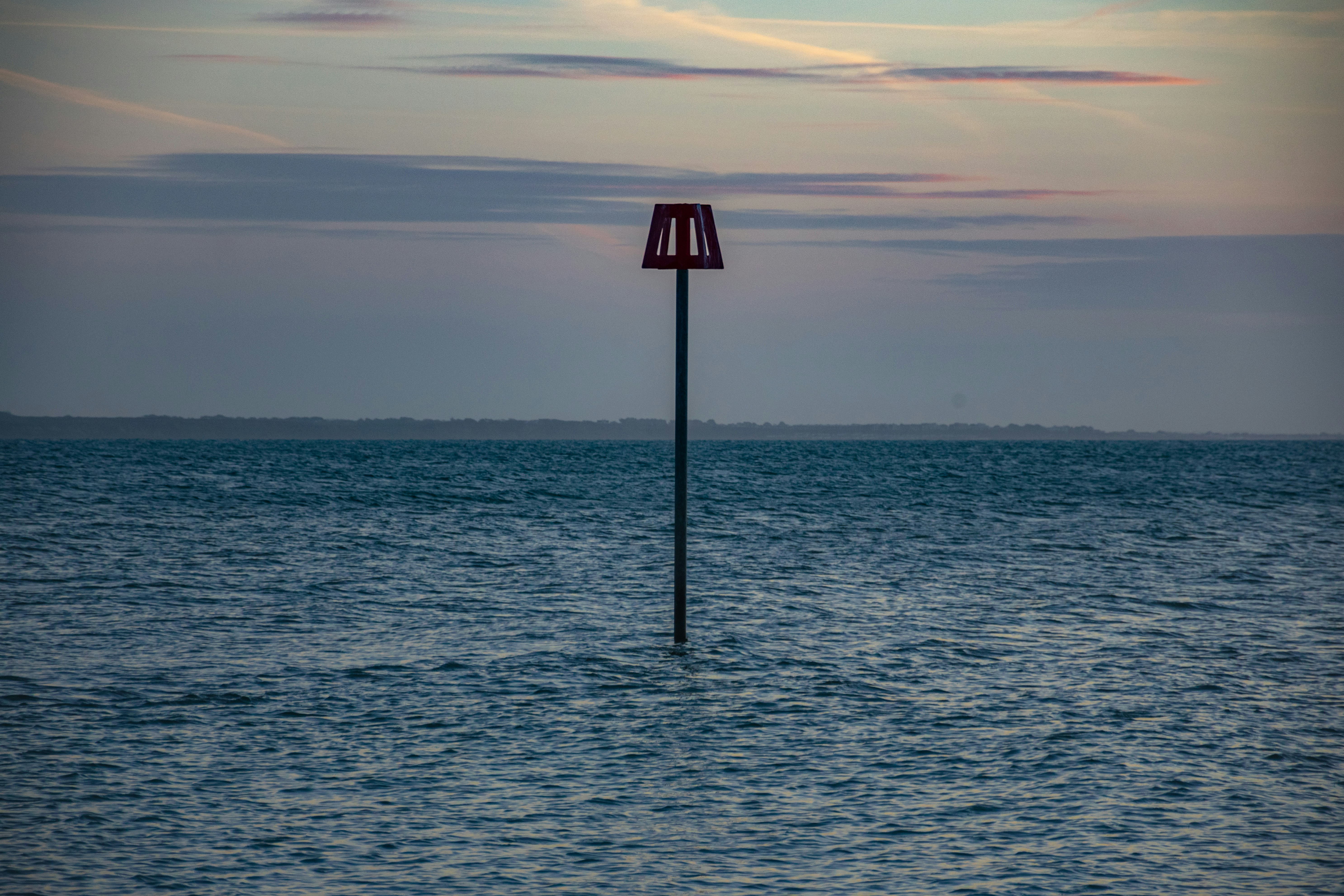 Lone Beacon at Dusk: A Quiet Sentinel Over Calm Seas