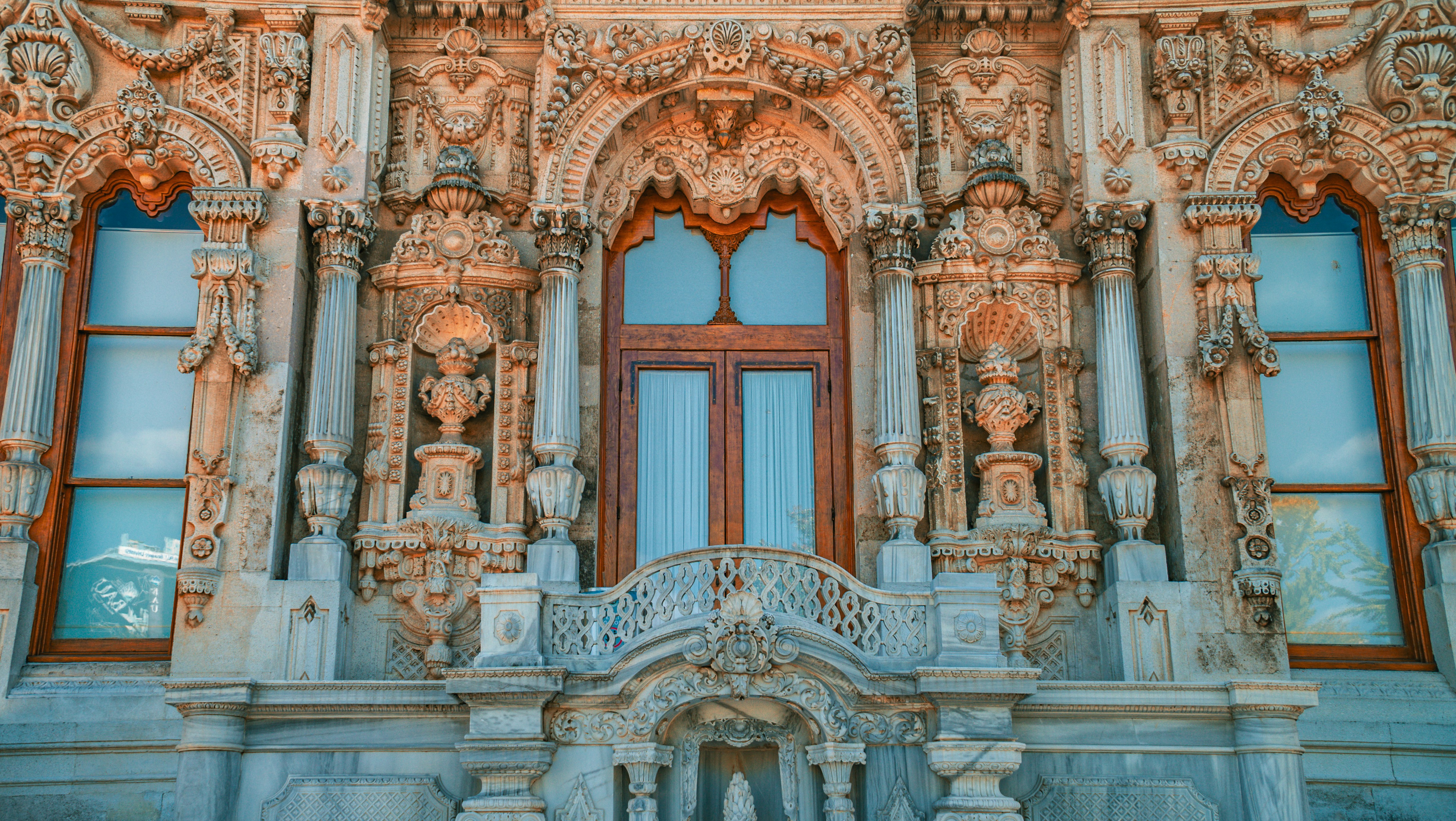 Lacework at the Center: Balcony-Framed Window Surrounded by Ornate Carvings