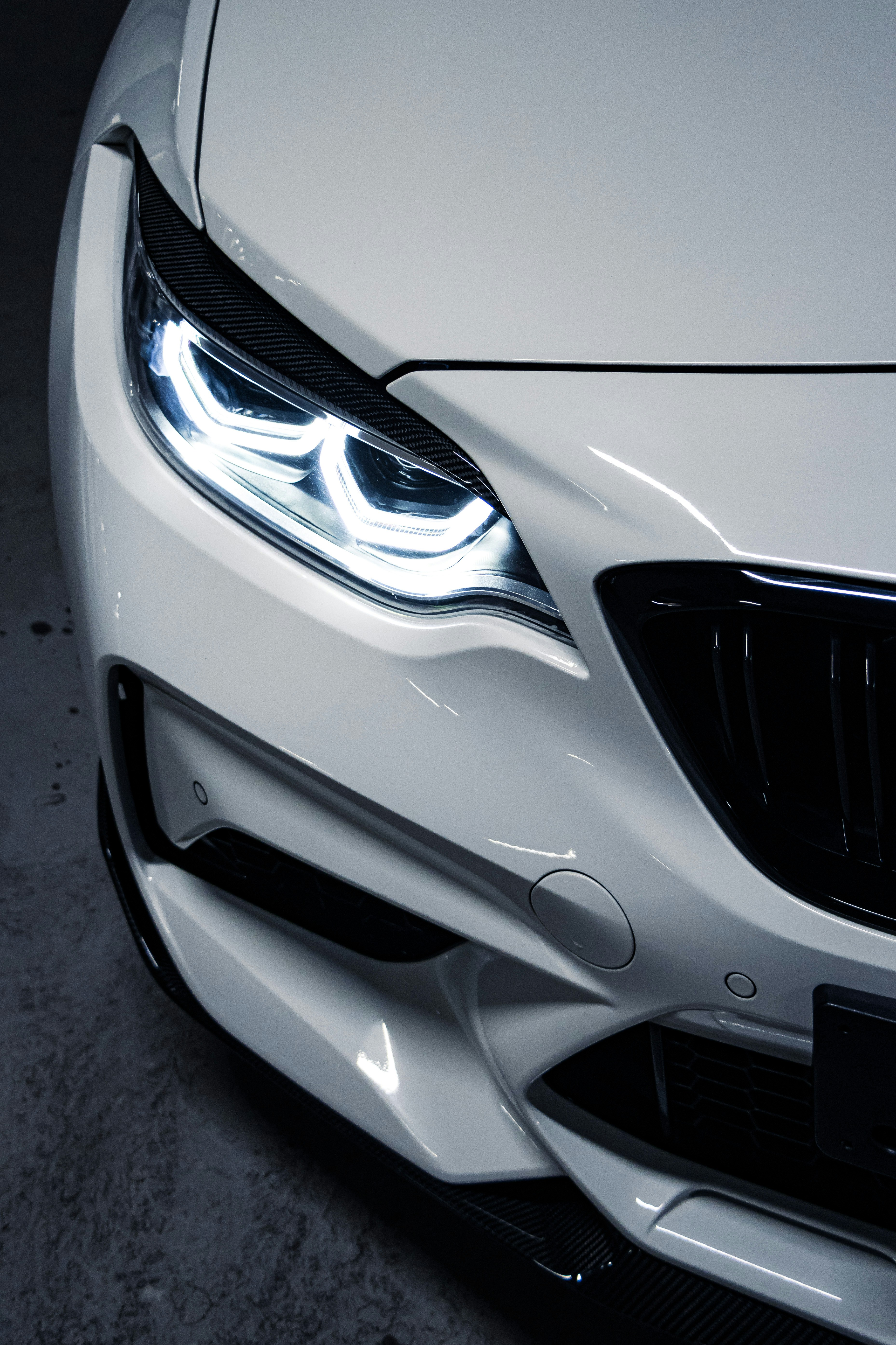 La parte delantera de un coche blanco con las luces encendidas foto ...