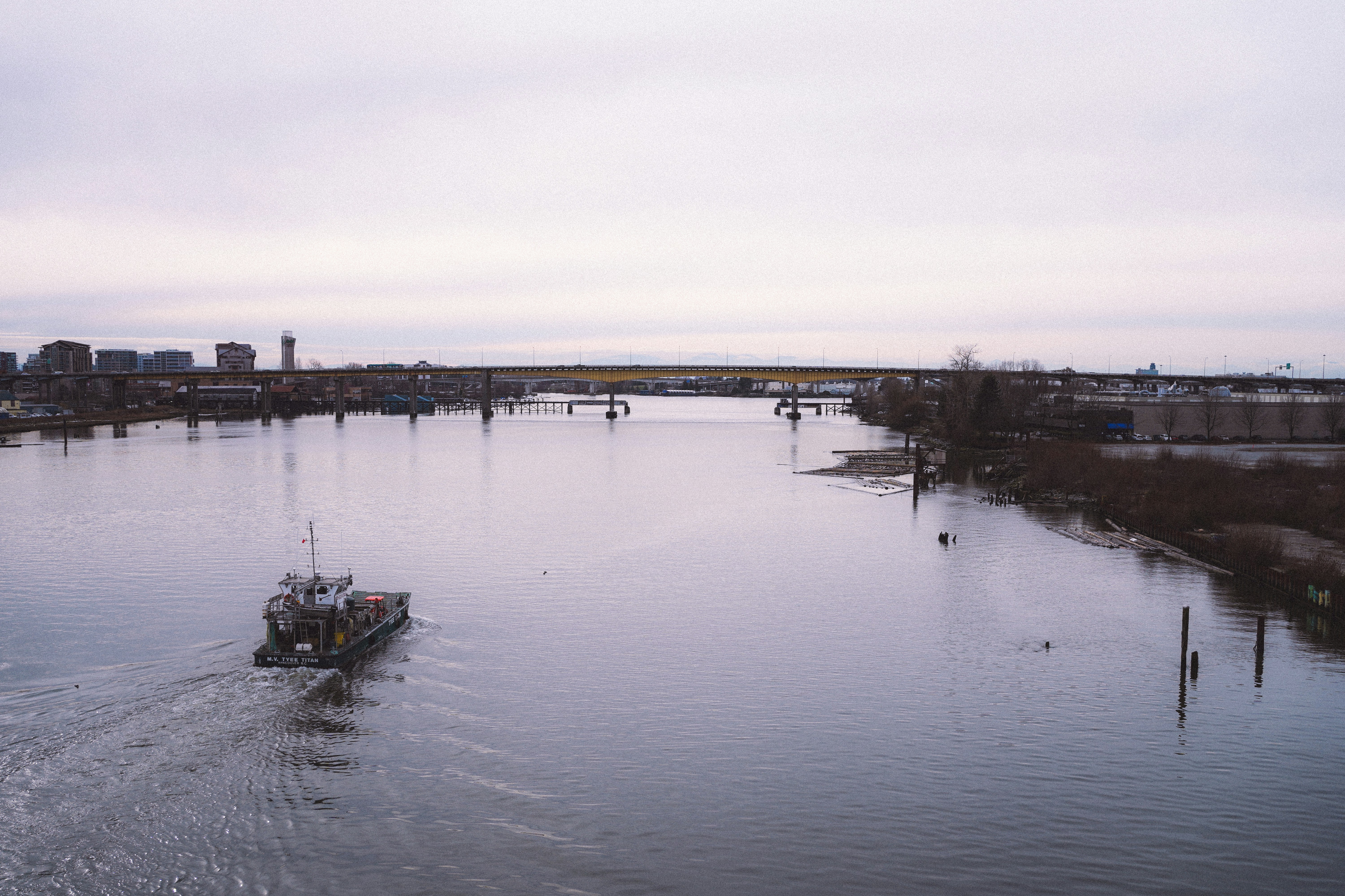 a boat traveling down a river next to a bridge