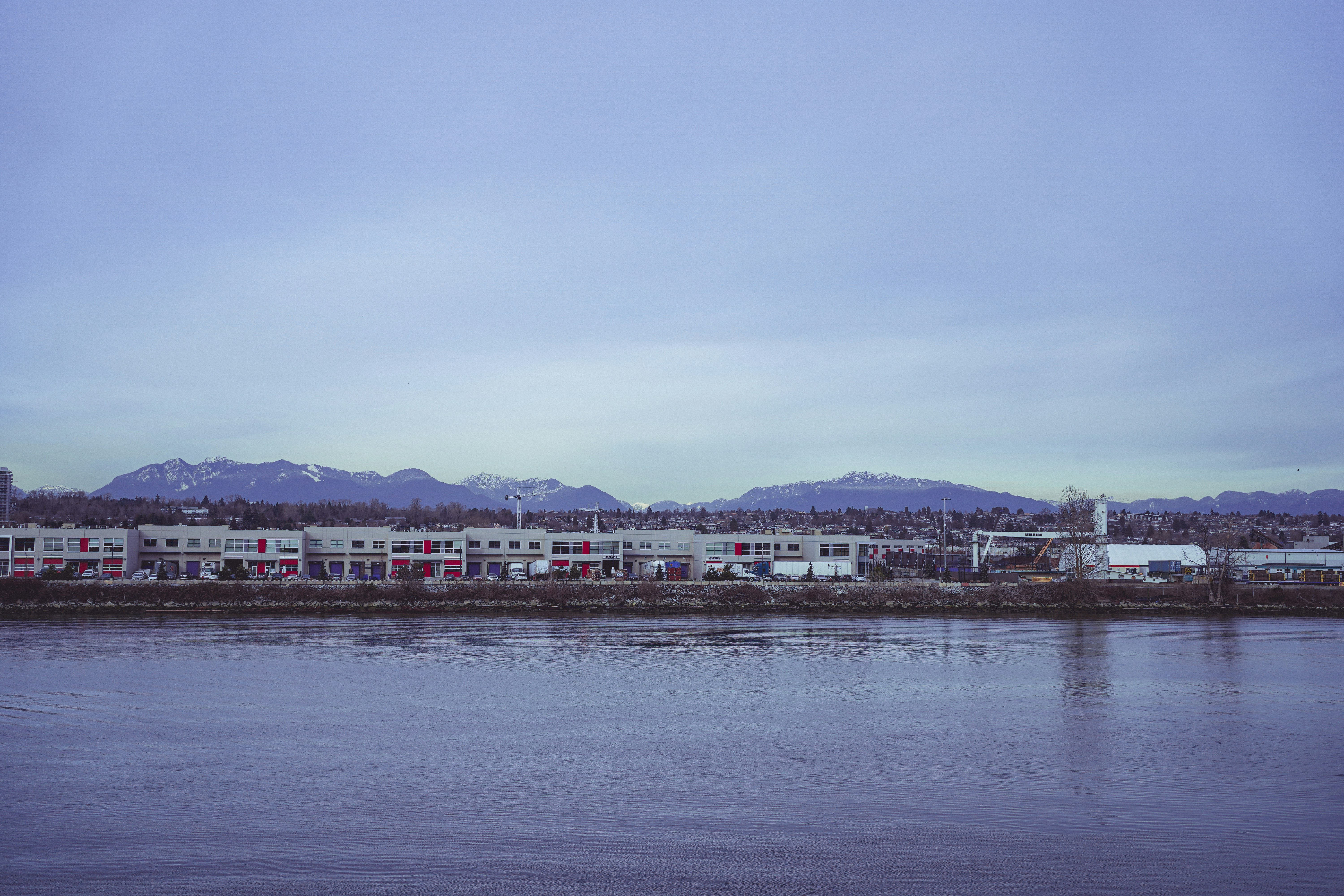 A body of water with buildings and mountains in the background photo ...