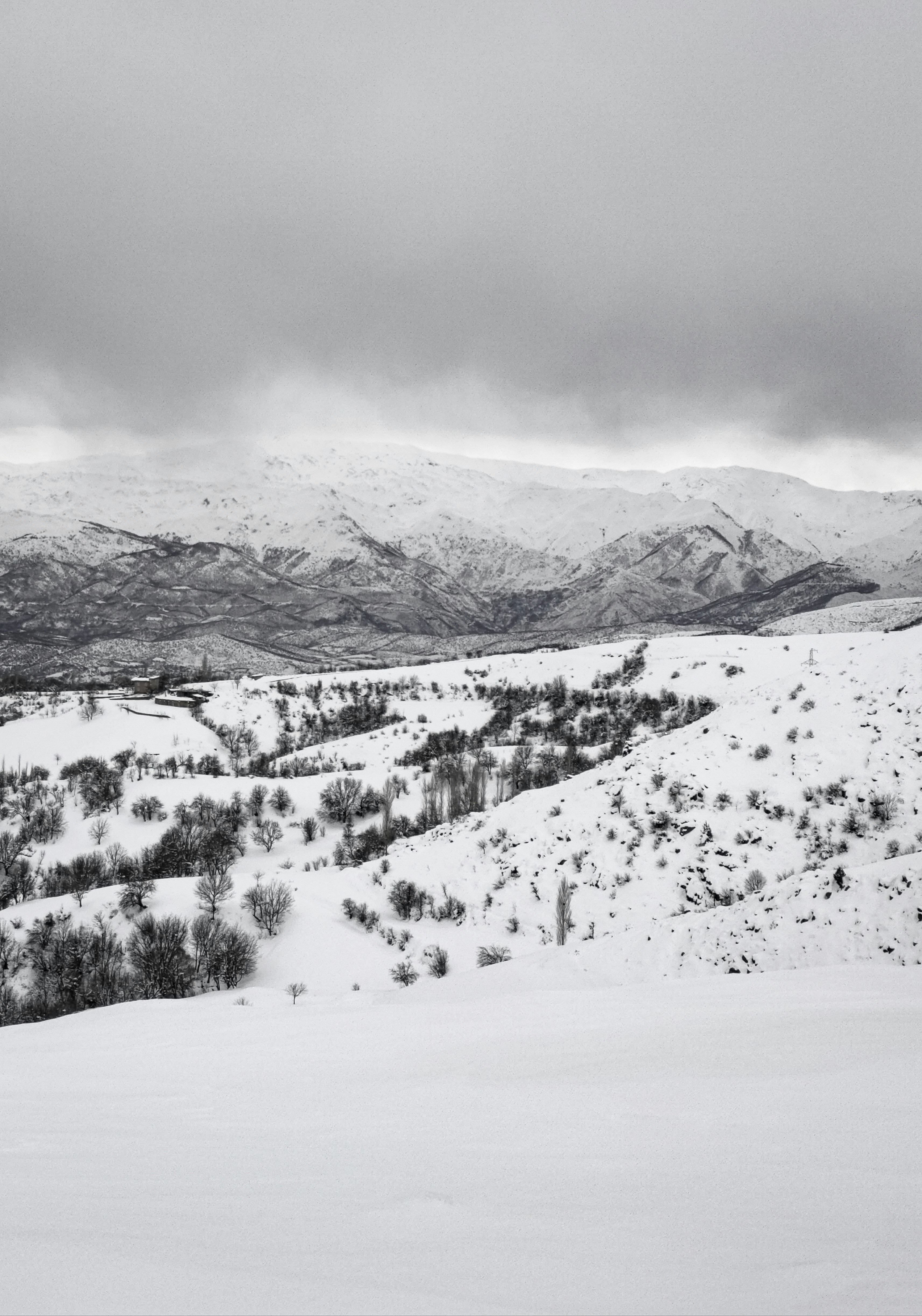 Snowbound Ridge: A Monochrome Alpine Panorama under a Looming Sky