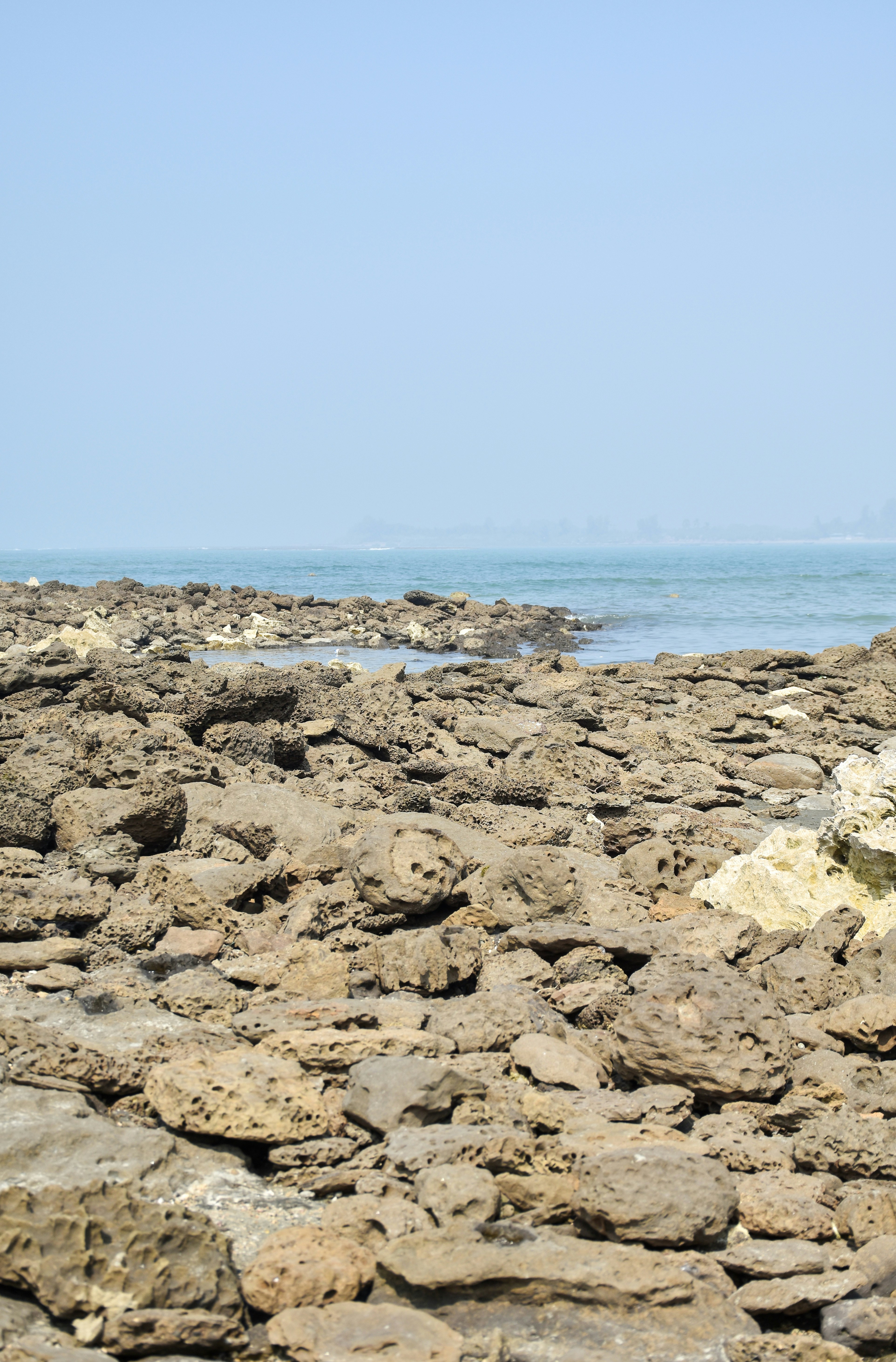 a person standing on a rocky beach next to the ocean